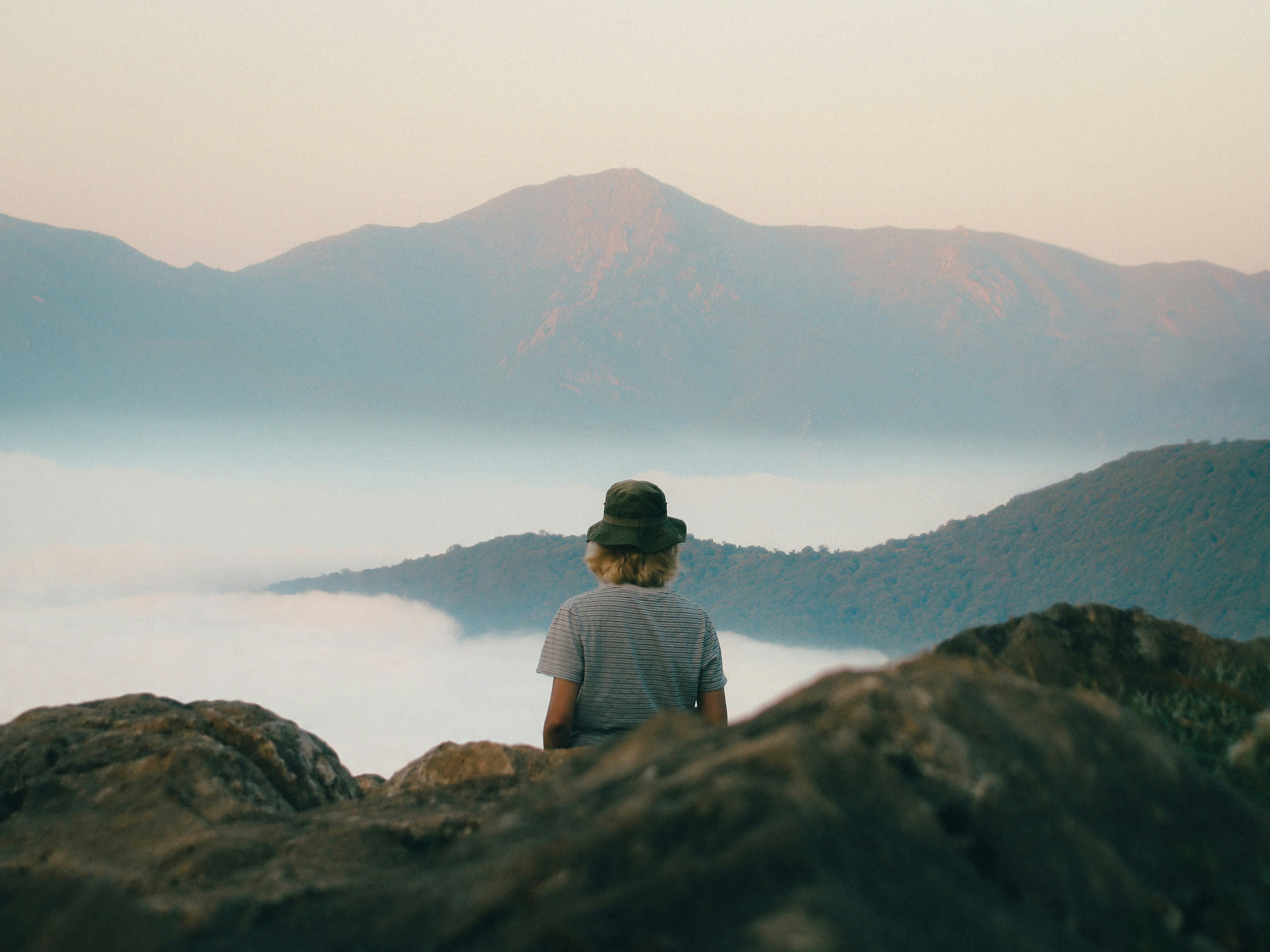 Silhouette at Dawn: A Voyager Amid Mist and Mountain Promontories