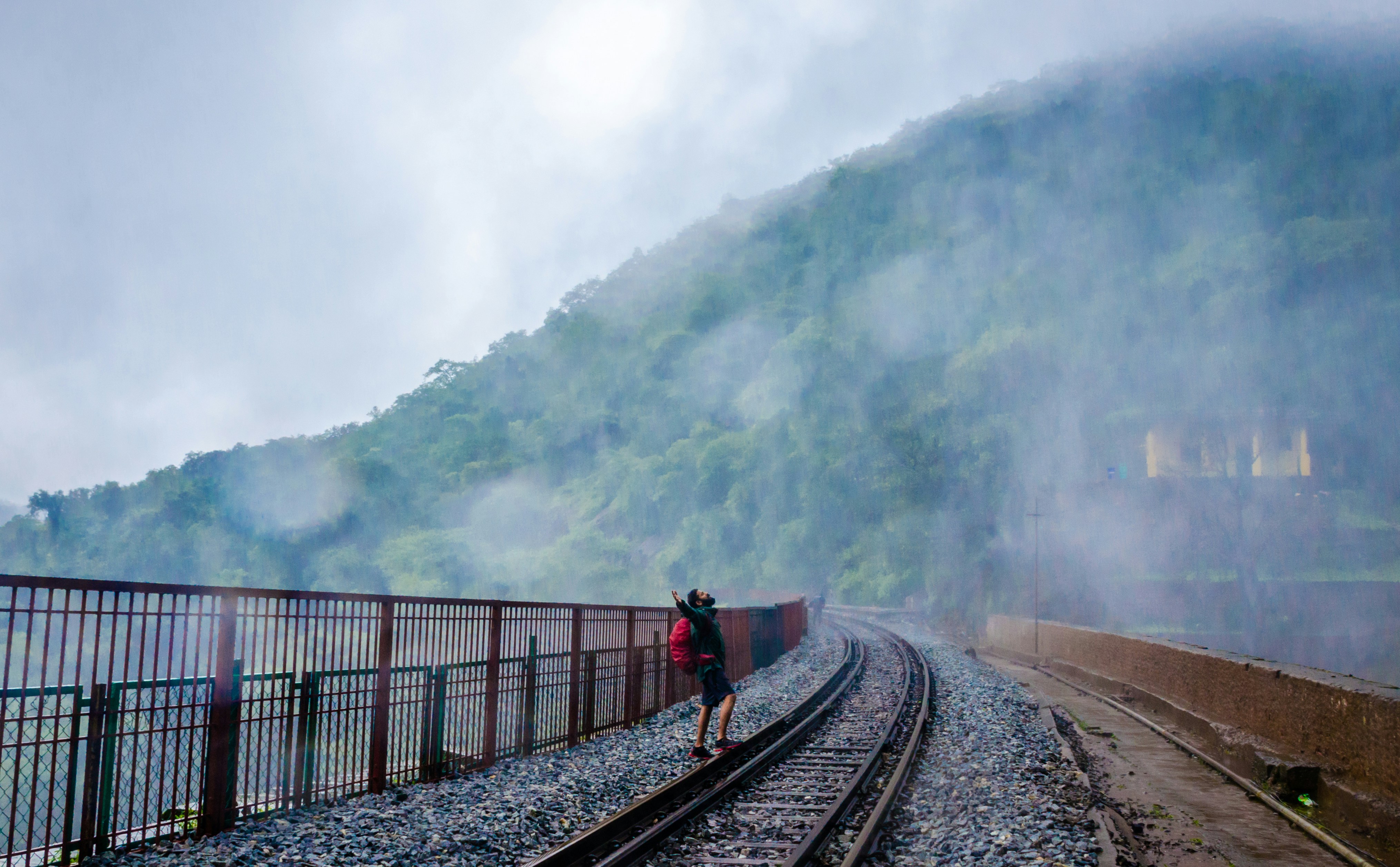On the Edge of the Ridge: A lone hiker on foggy railway