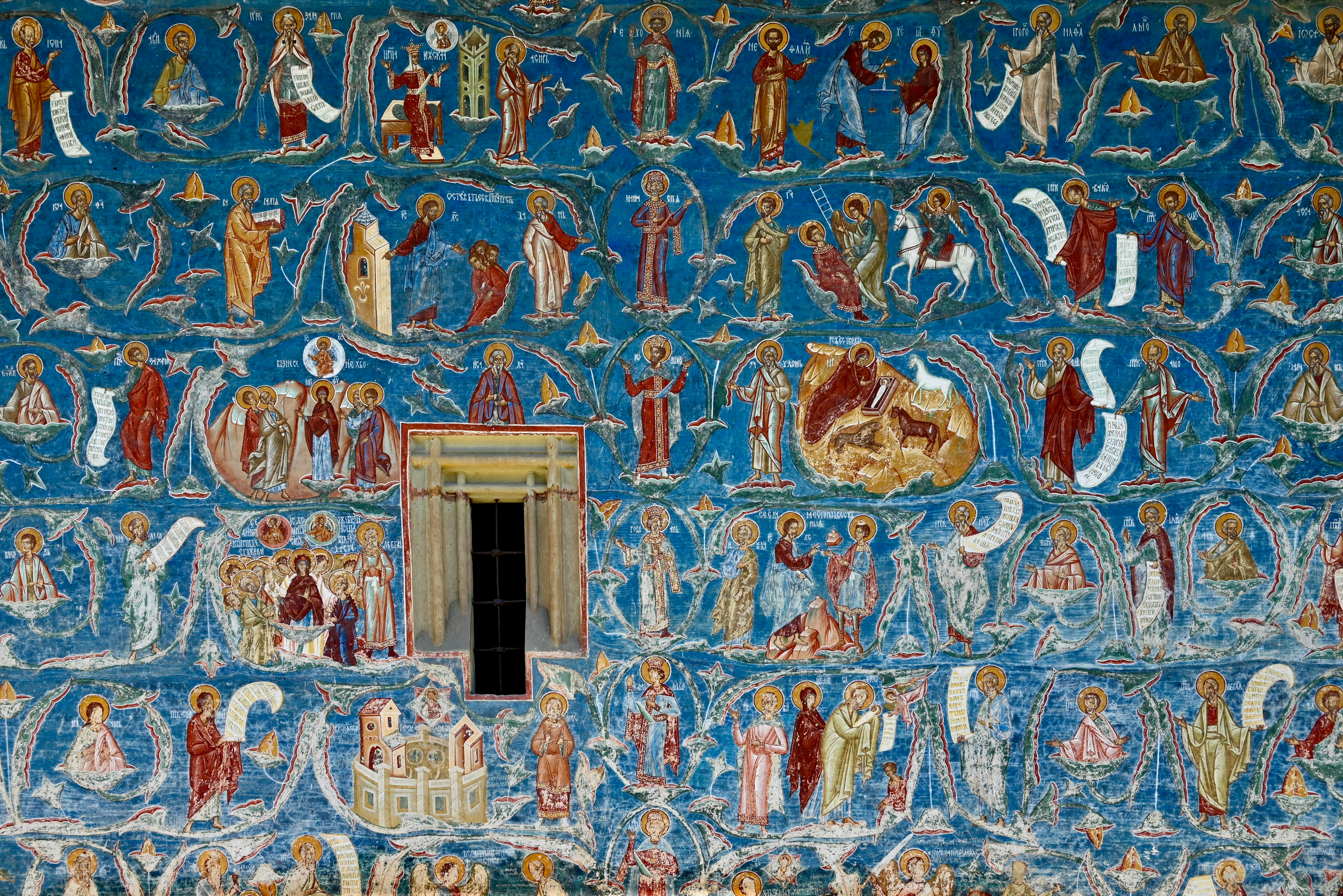 Mosaic Wall of Saintly Figures: A Blue Tilled Fresco Corridor