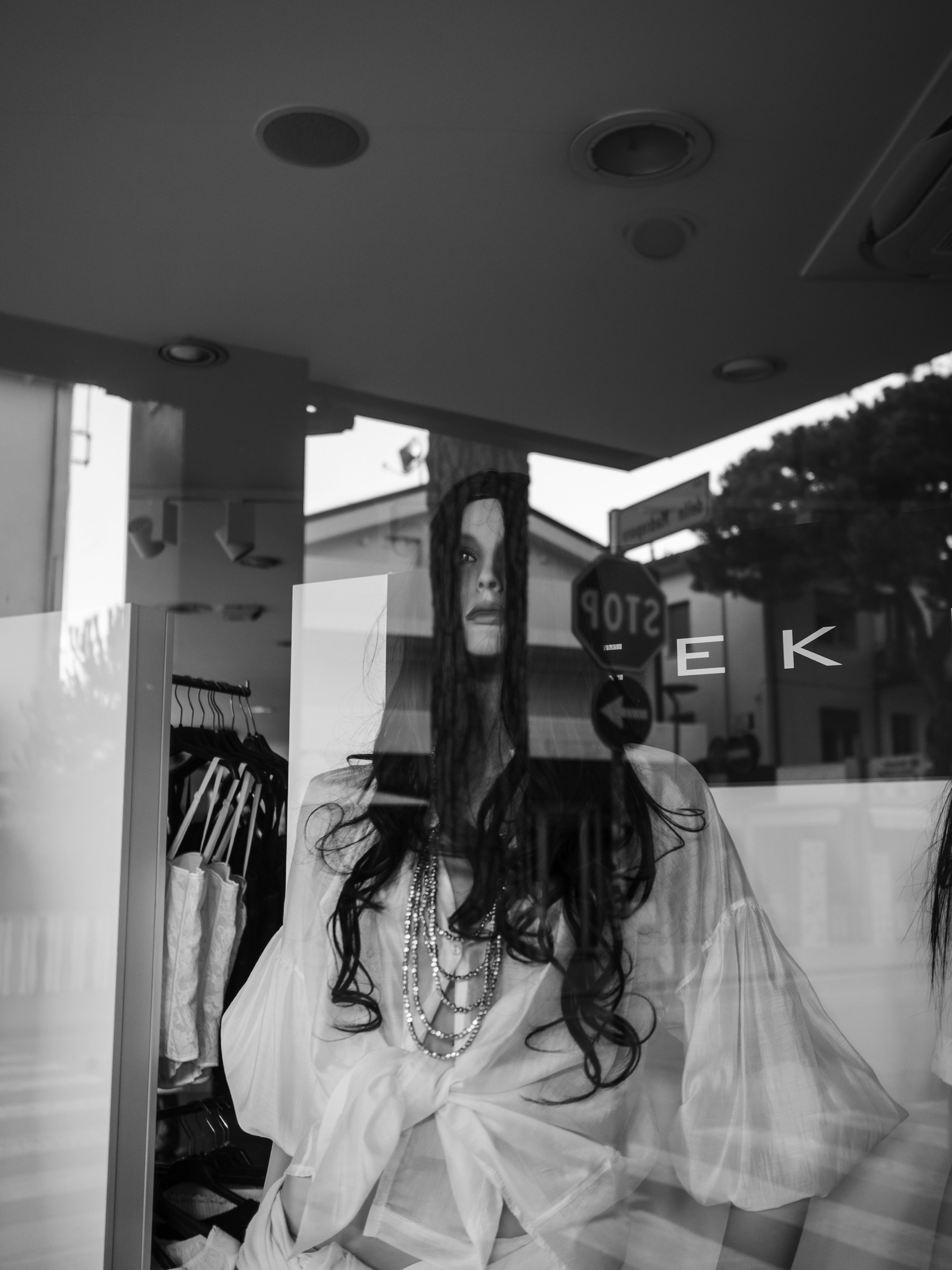 Megawatt mannequin: a moody storefront portrait in monochrome