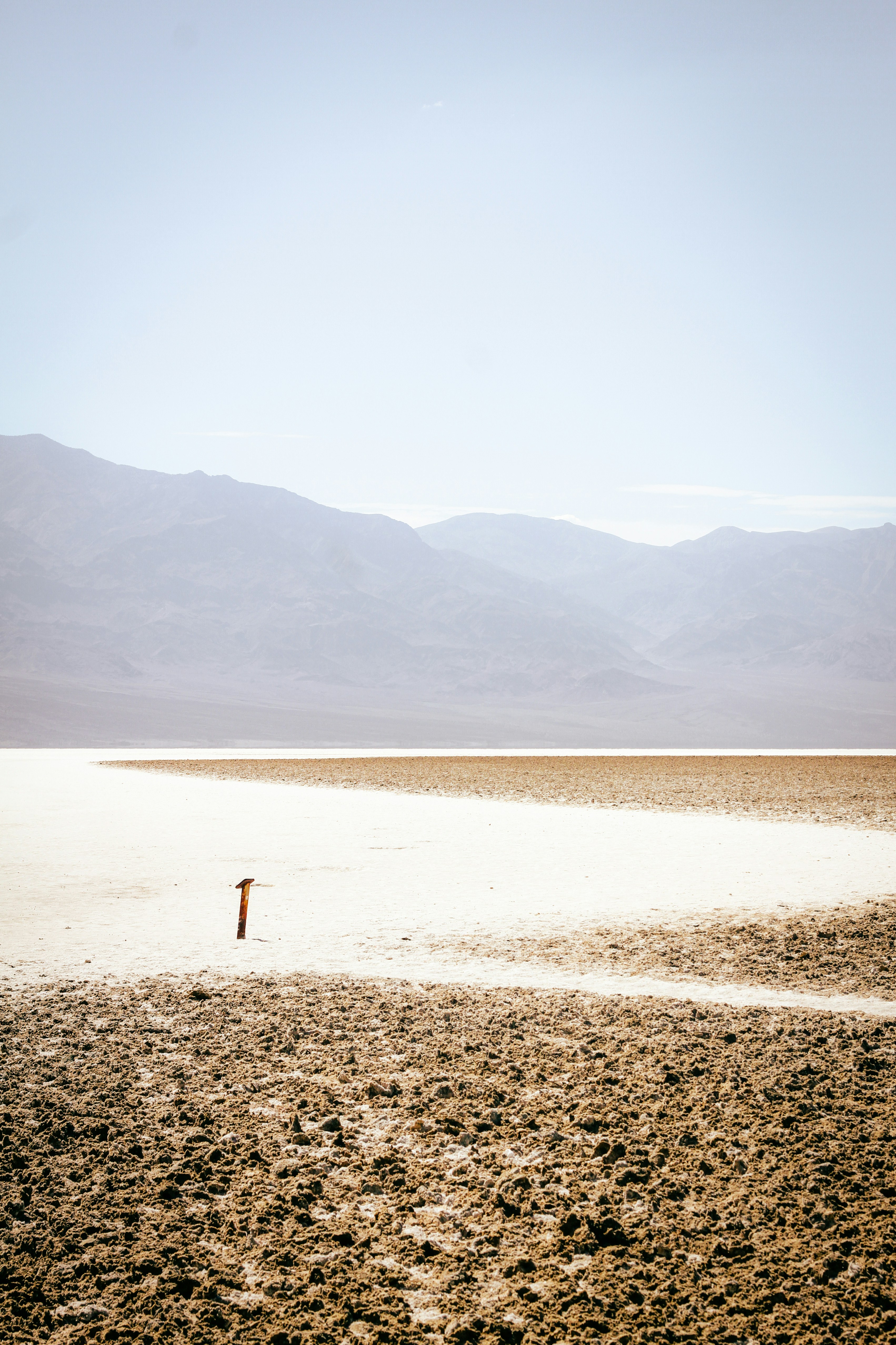 Salt Flats Under Quiet Skies: A Lone Marker in the Expanse