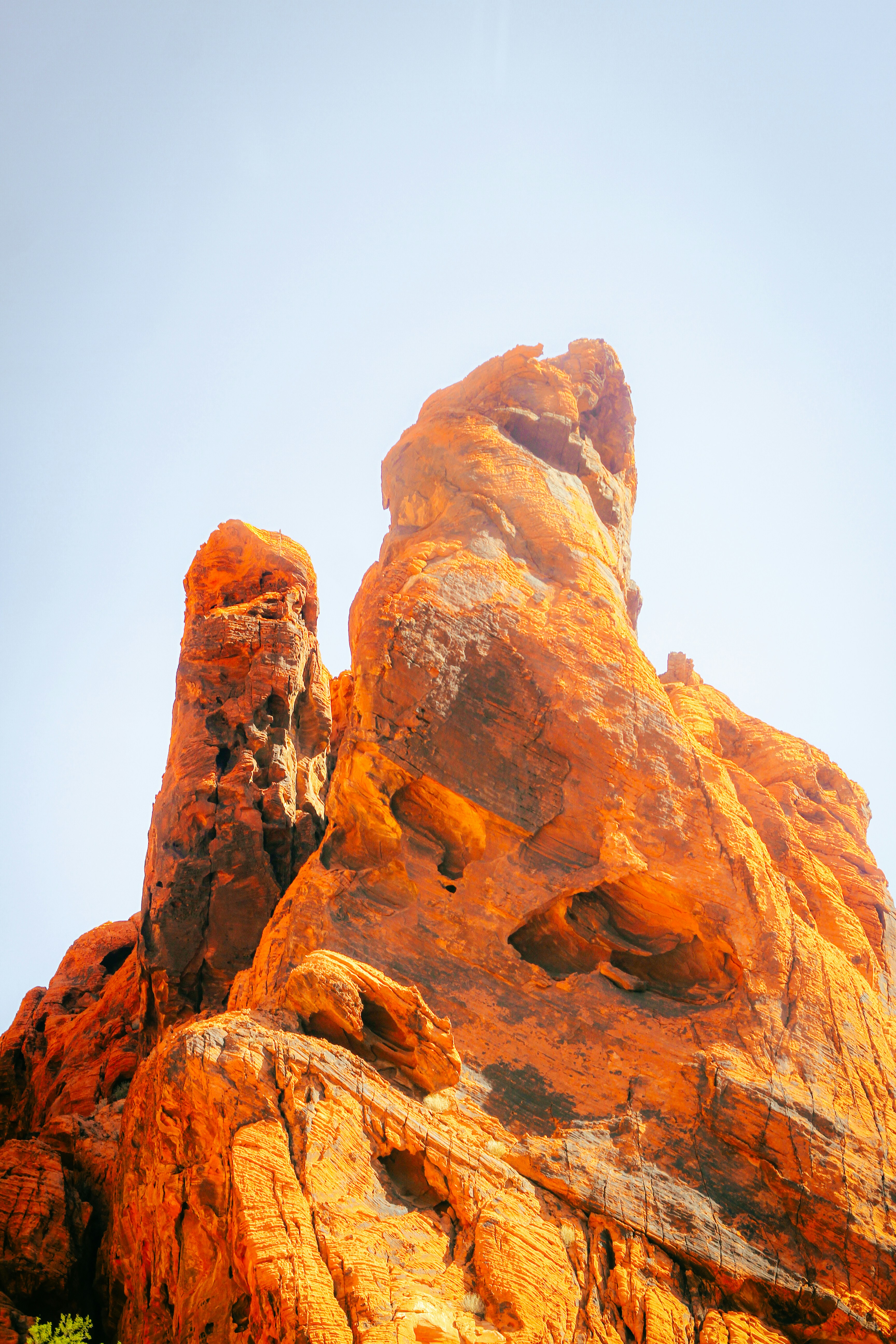 Sunlit Crimson Spire Ascending Against a Pale Sky