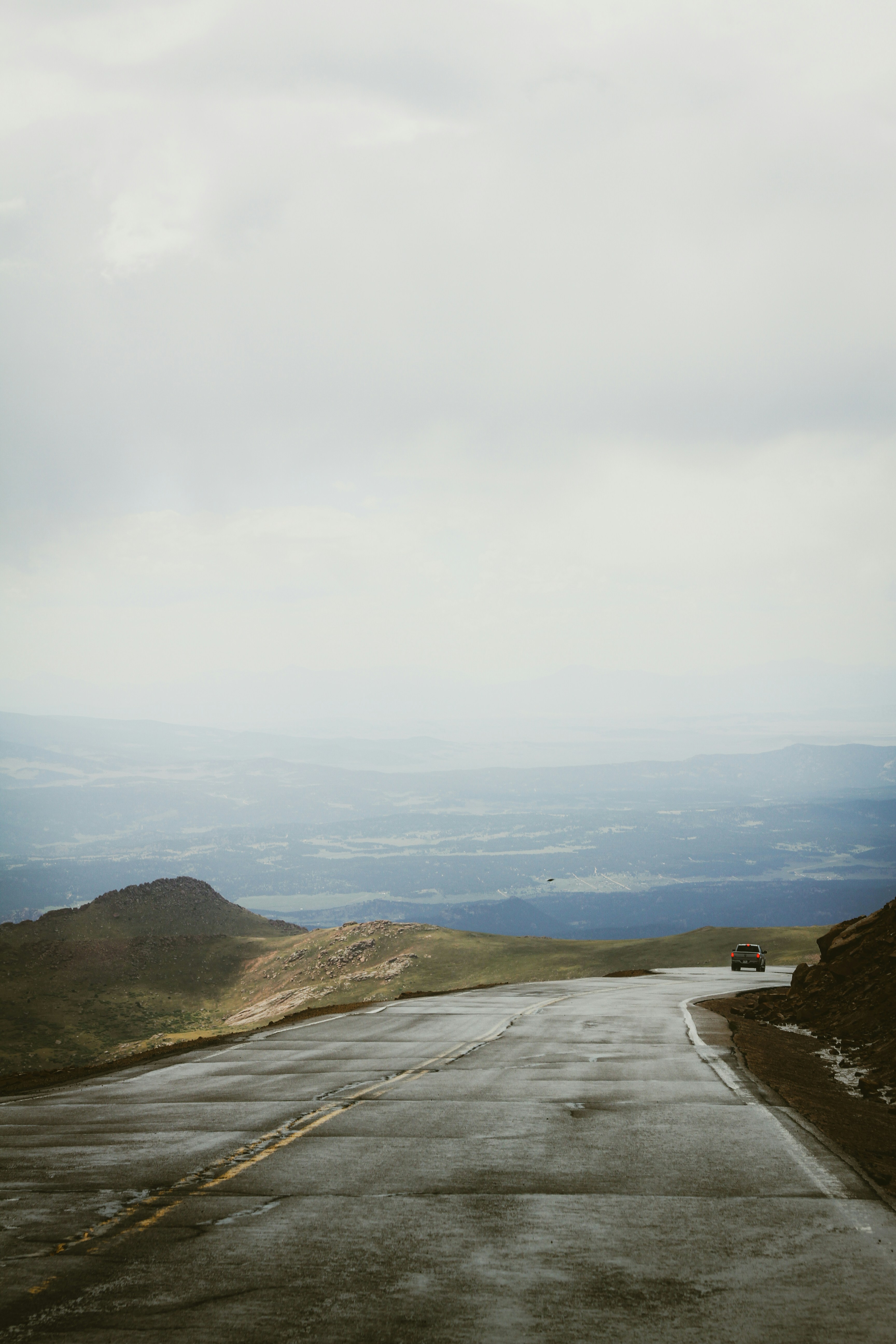 Lonely Car Climbing a Winding Mountain Road at Dusk