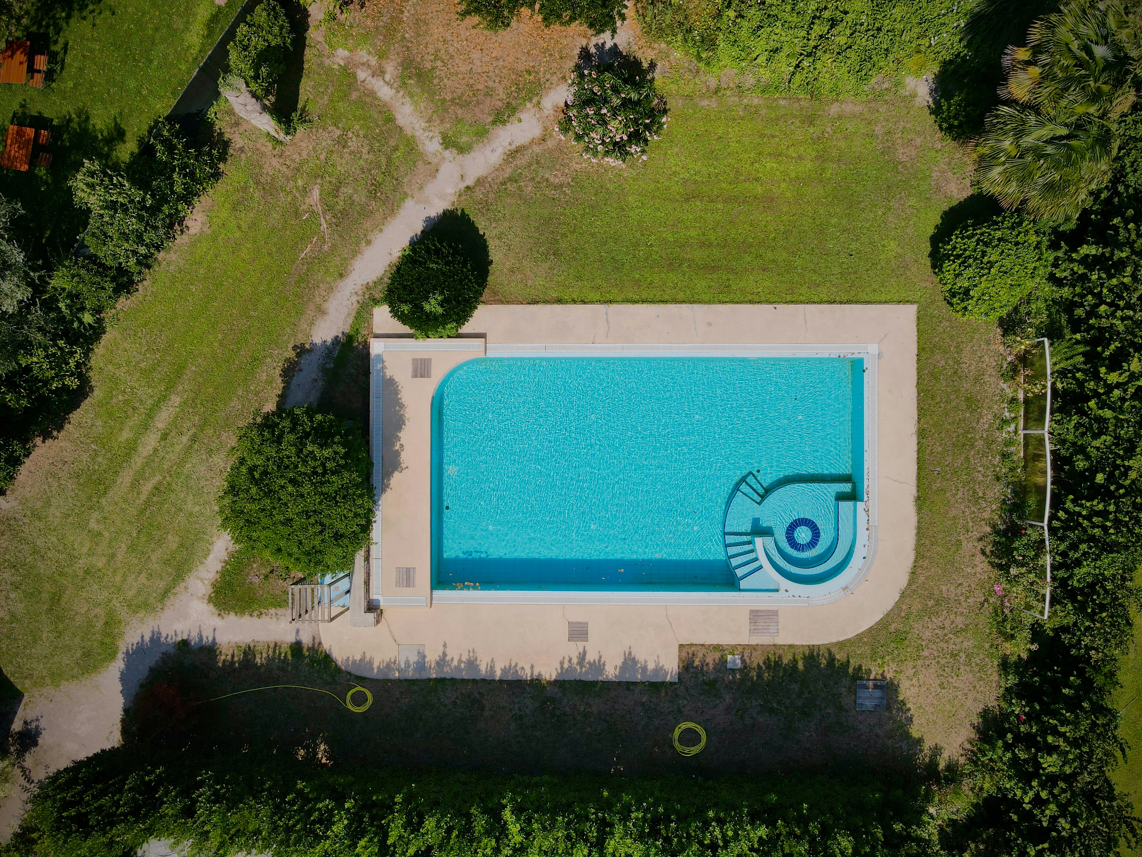 Aerial View of a Rectangular Pool Courtyard Surrounded by Greenery