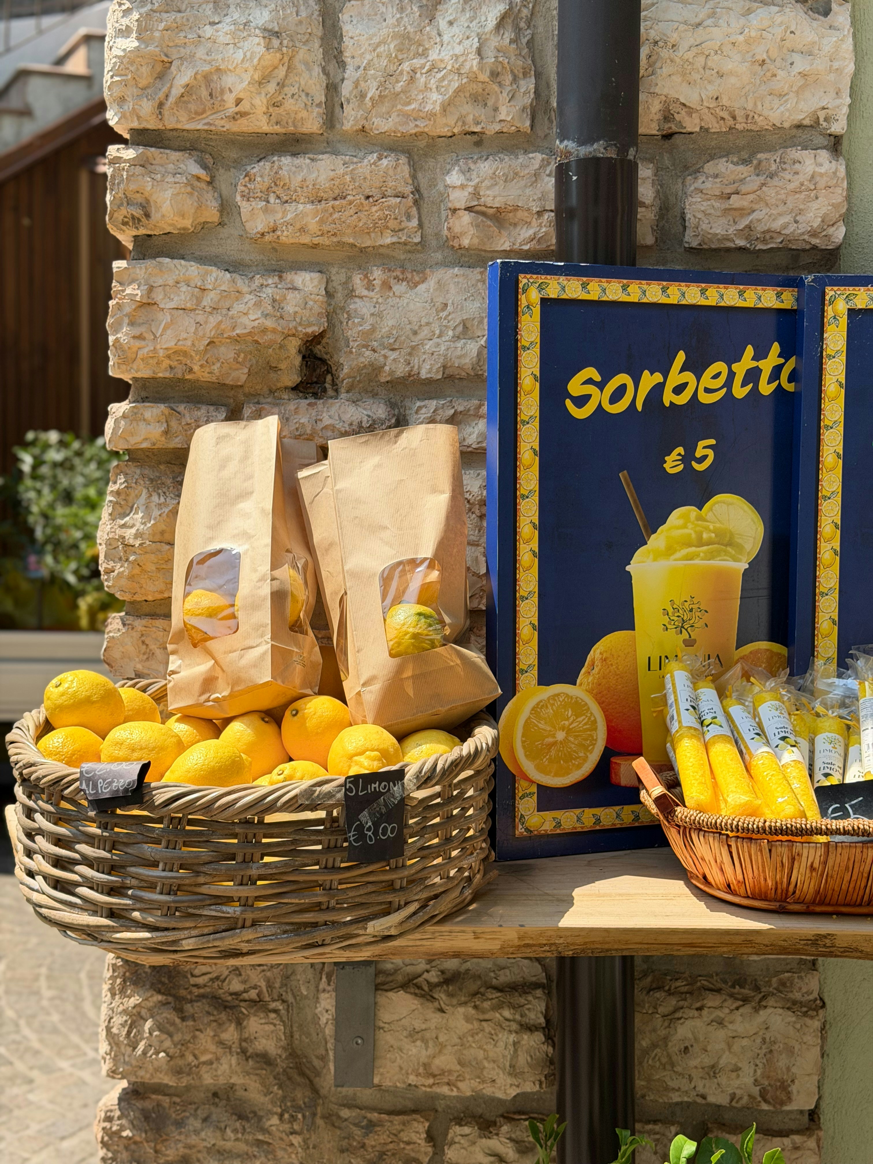 Citrus Market Stand Framed by Stone Wall and Soleil Sign
