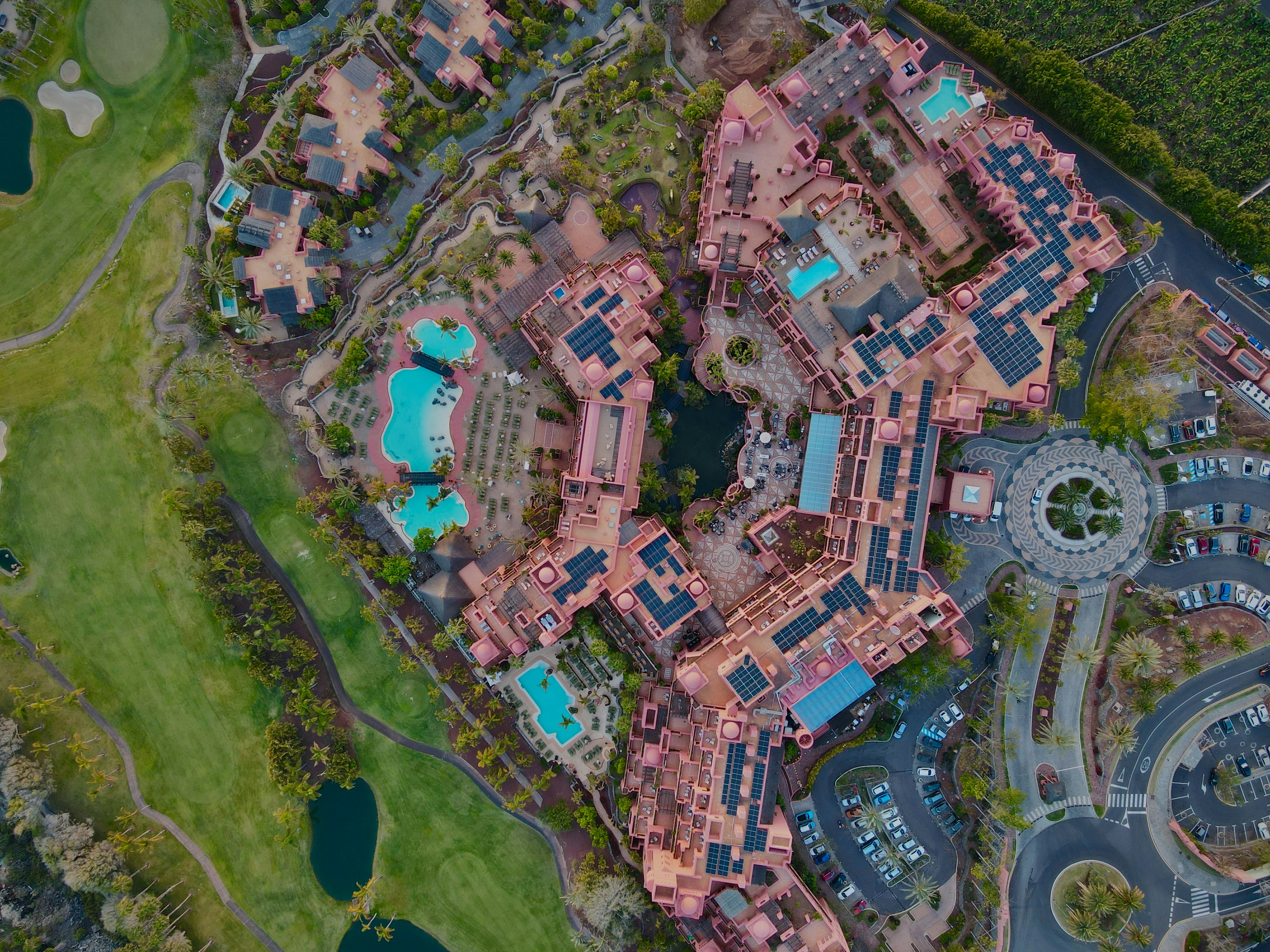 Aerial mosaic of a resort complex with winding pools and terracotta-roofed buildings