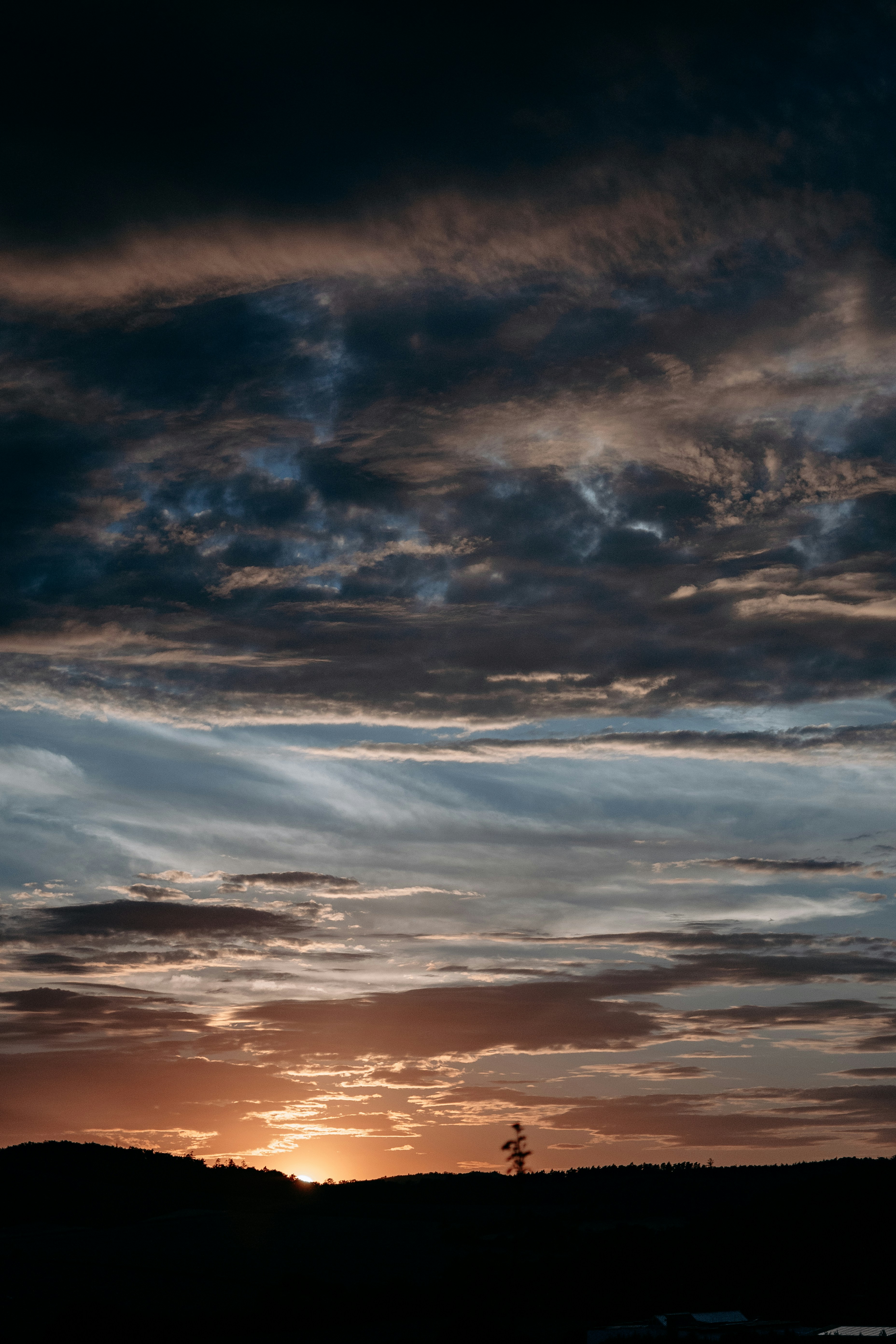 Sunset Edge: Dark Horizon Beneath a Dramatic Sky