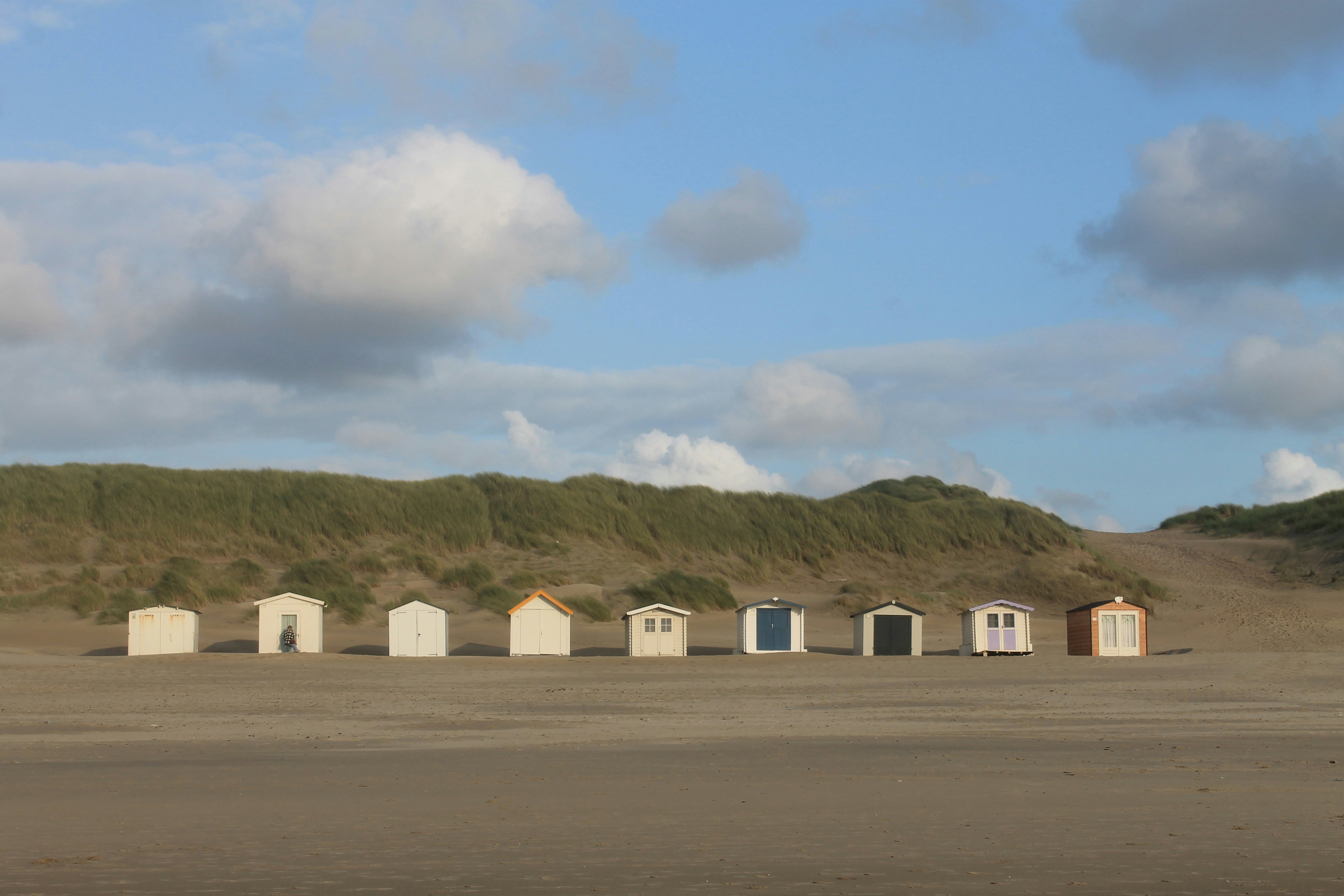 Row of pastel beach huts under a calm sky