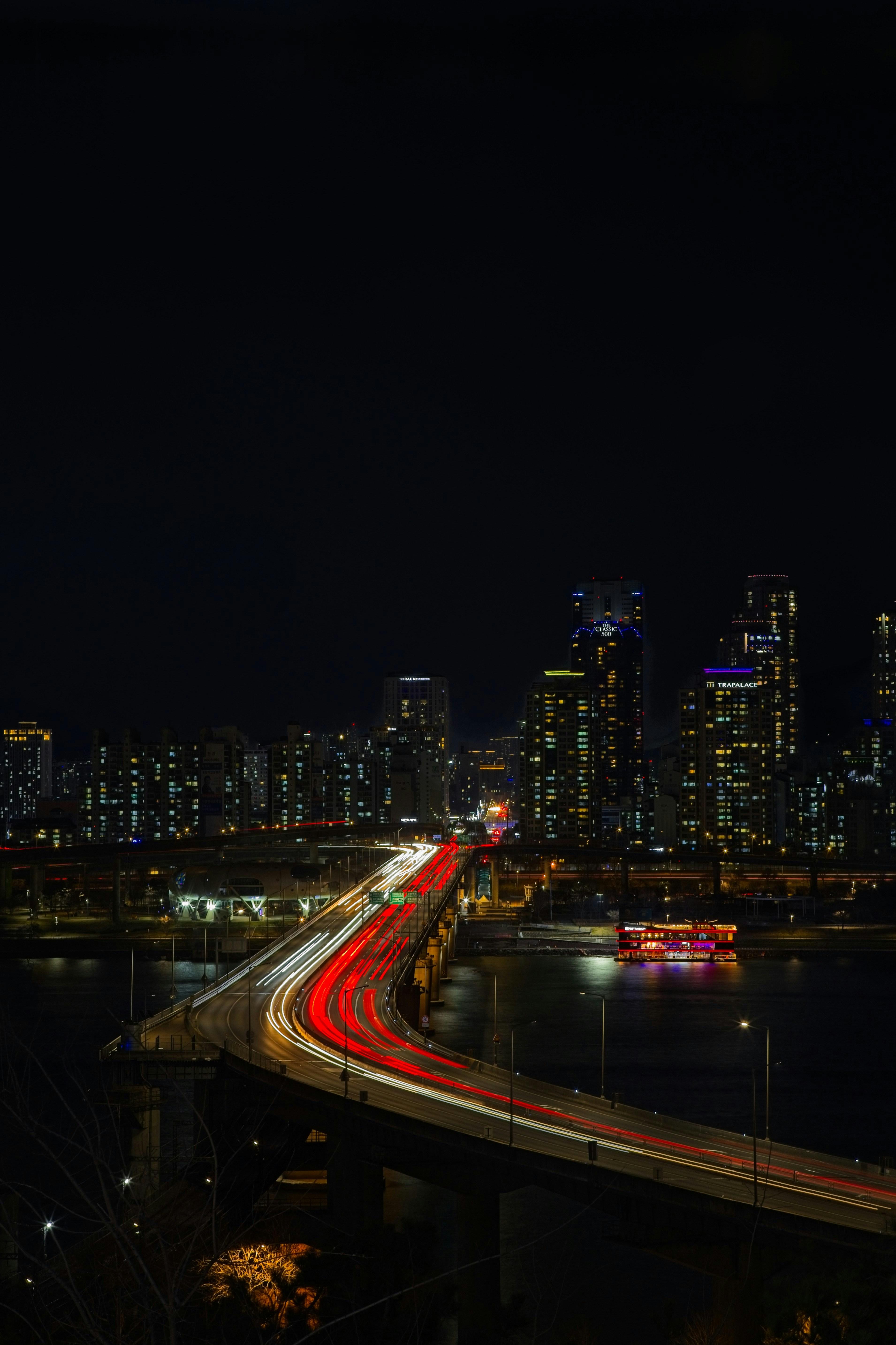 Neon Arteries: Nighttime River City Bridge