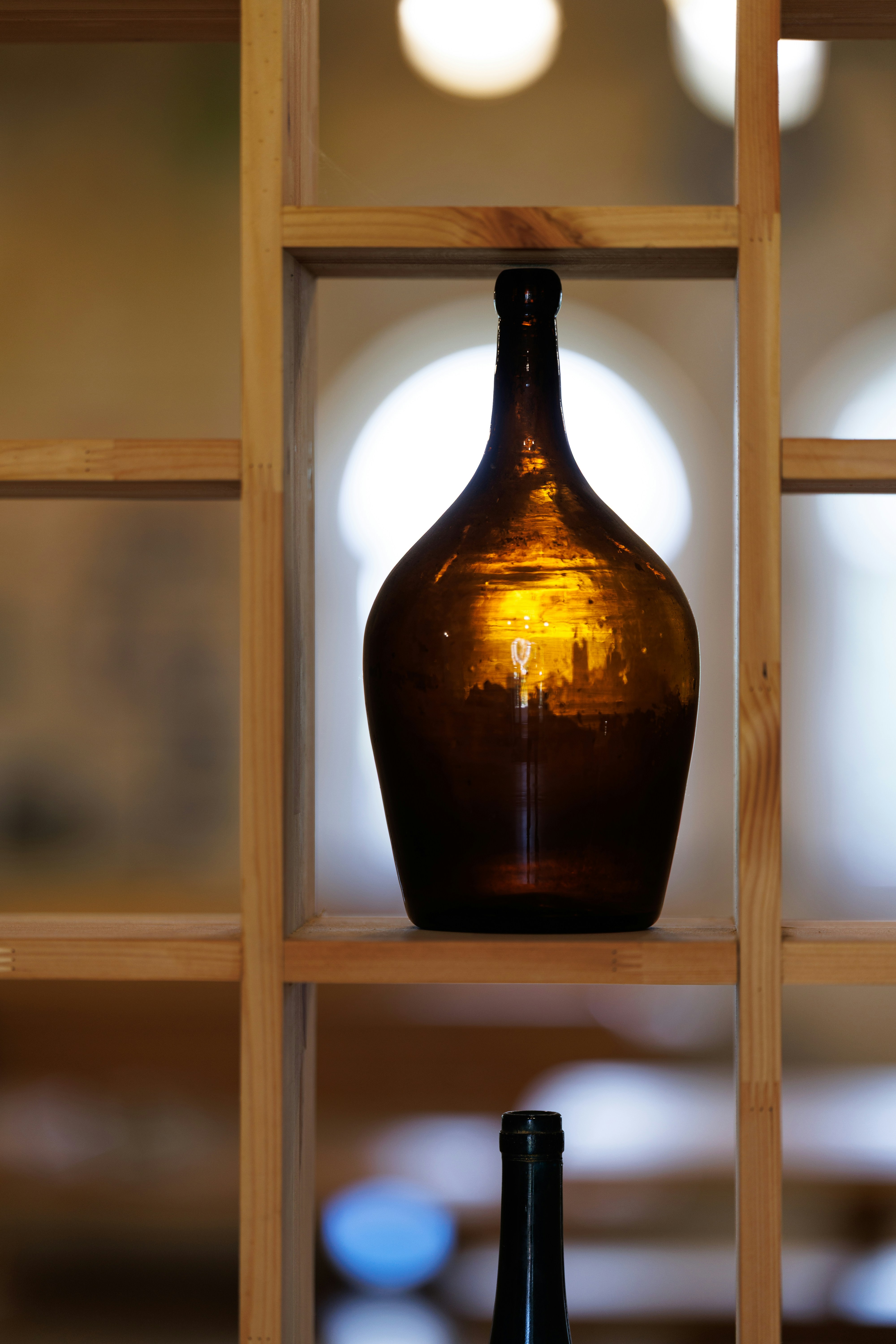 Amber Glass Through Wooden Grids: A Portrait of Quiet Craft