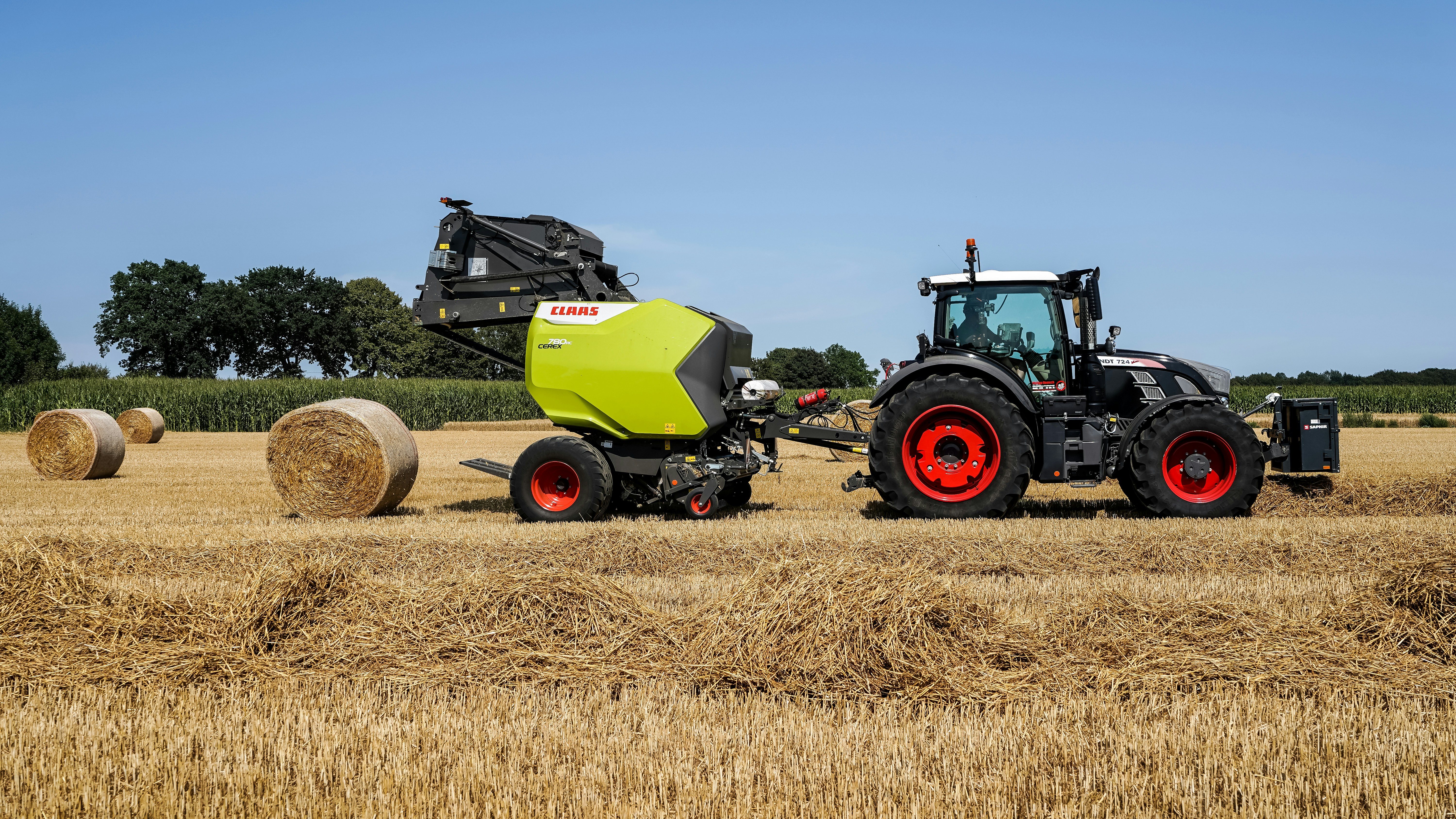 Harvest Relay: The Tractor and Bale Harvester in a Golden Field