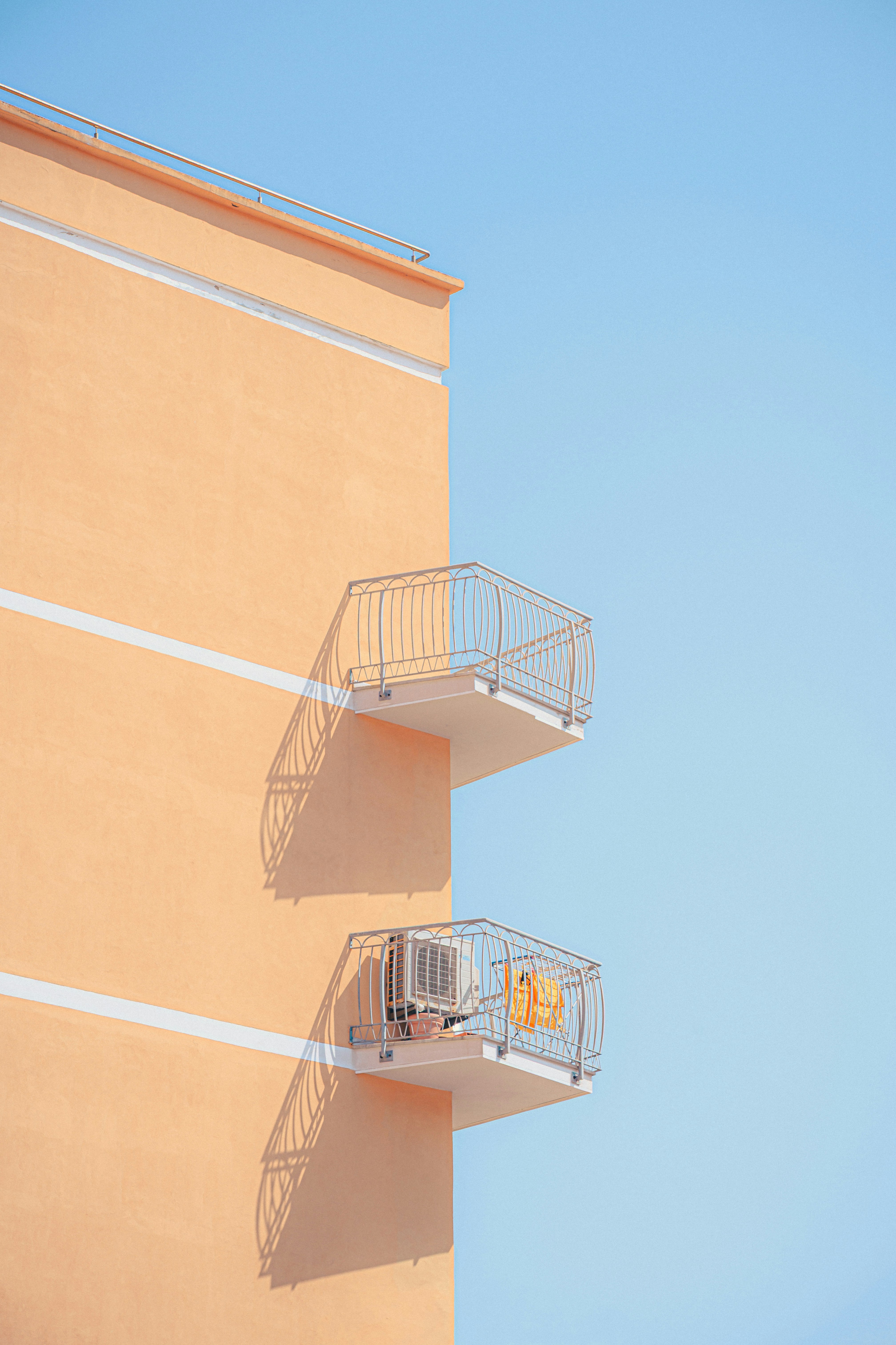 Sunlit Balcony Shadows on a Peach‑Plastered Wall