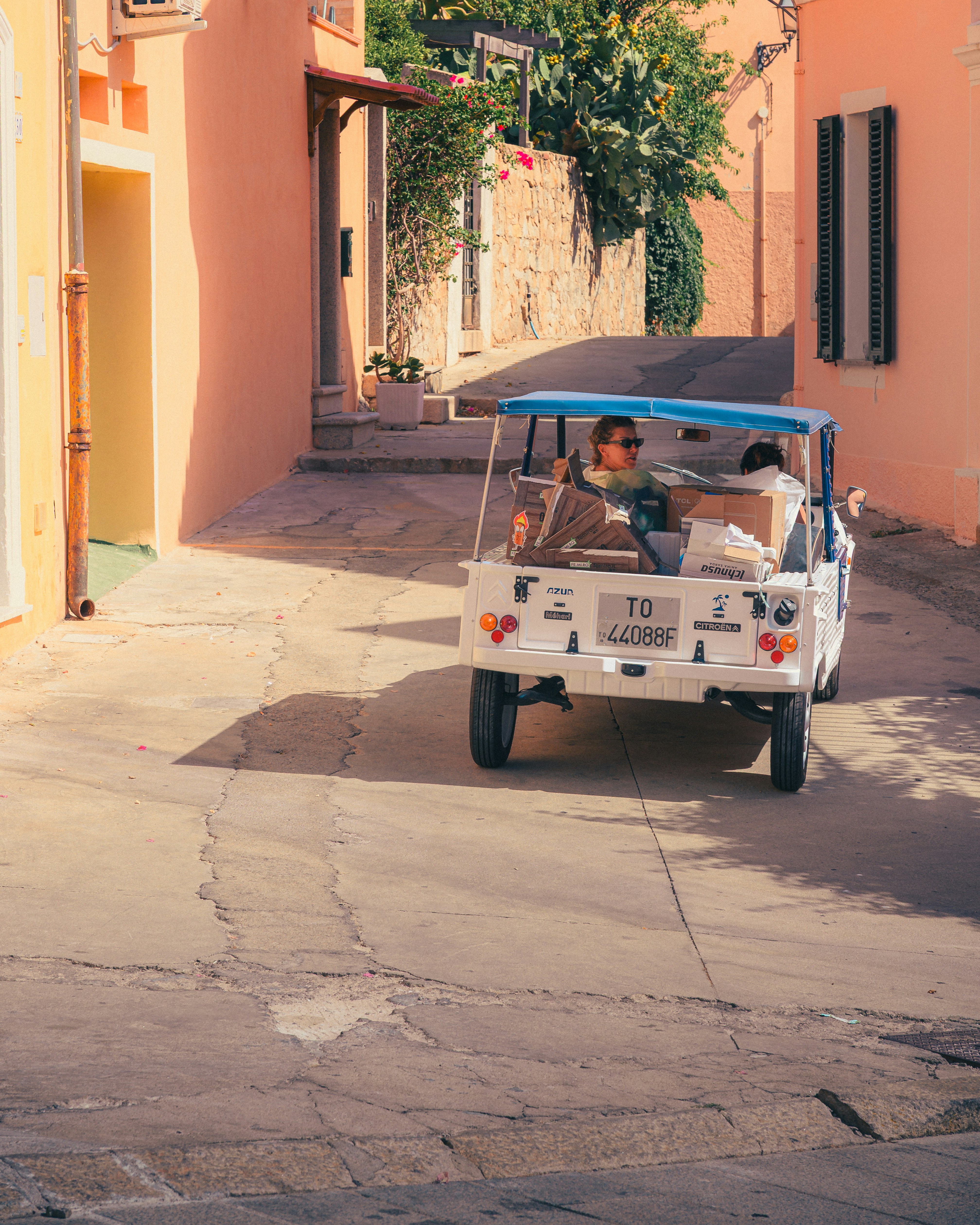 Sunny Street Ride: A Vintage Utility Vehicle Rounds a Warm Coastal Corner