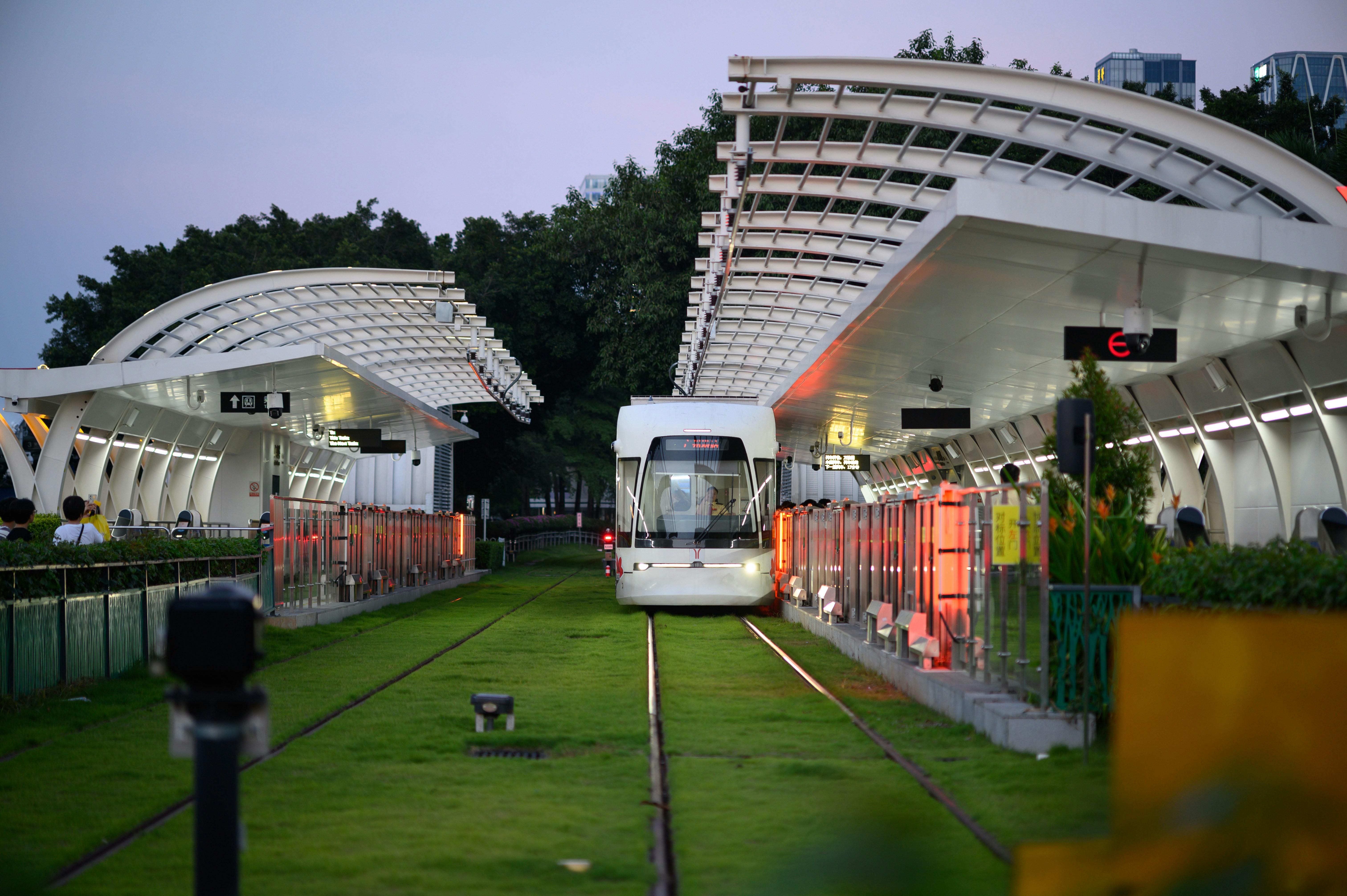 Central tram at the sunlit platform: symmetry and rails