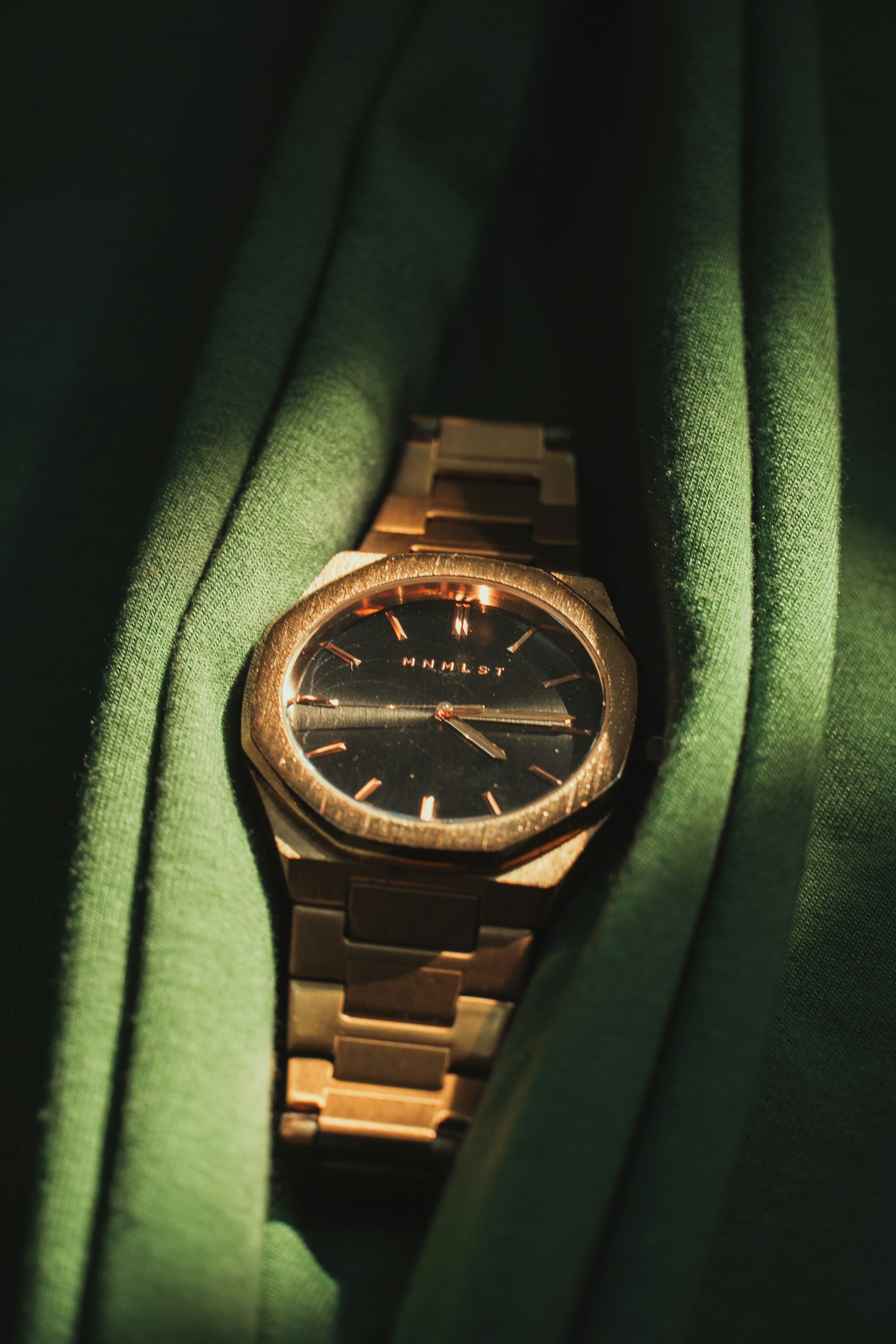 Gold Timepiece Tucked Between Emerald Drapes