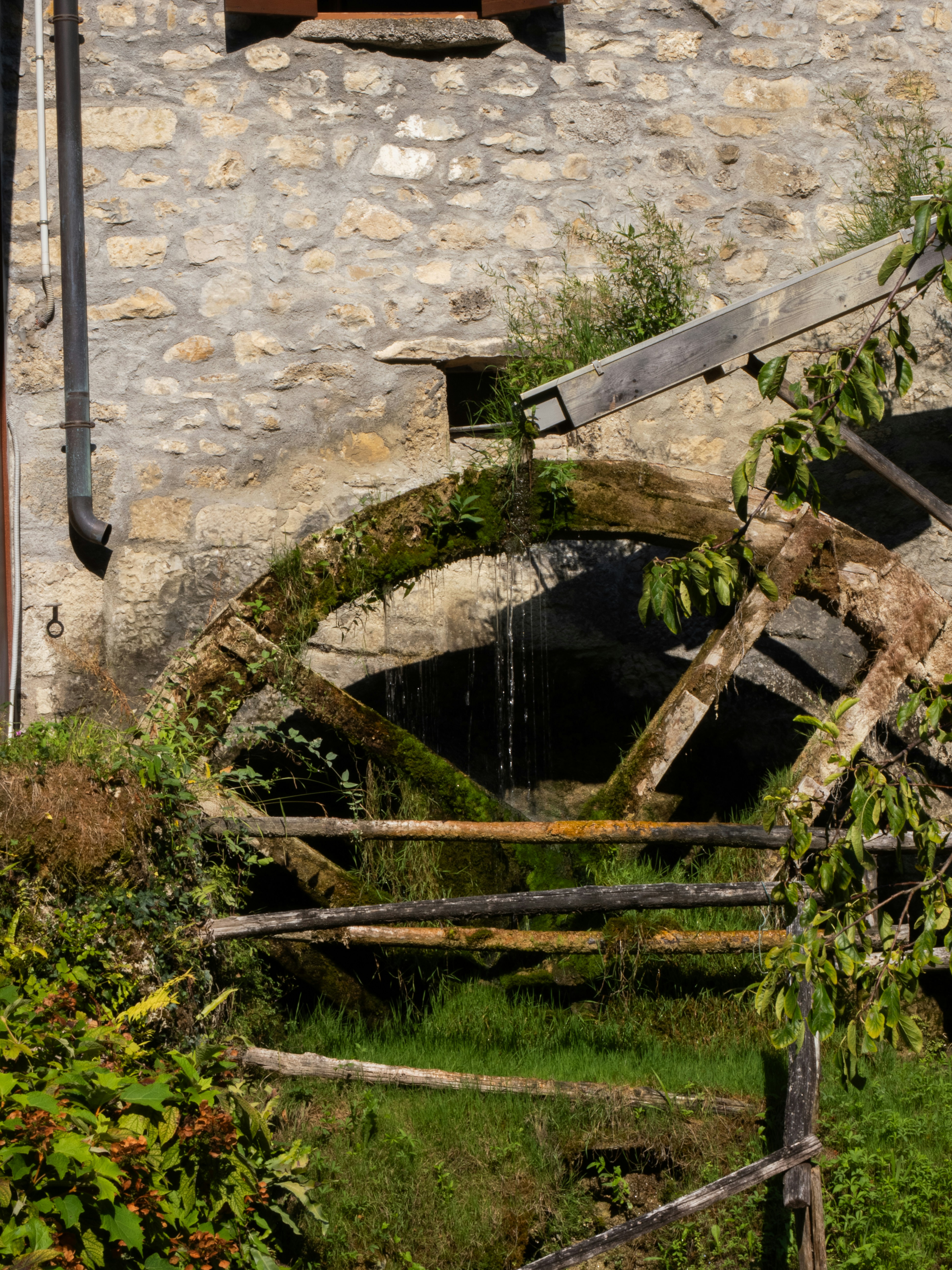 Old Water Wheel overgrown with Moss in Stone Mill