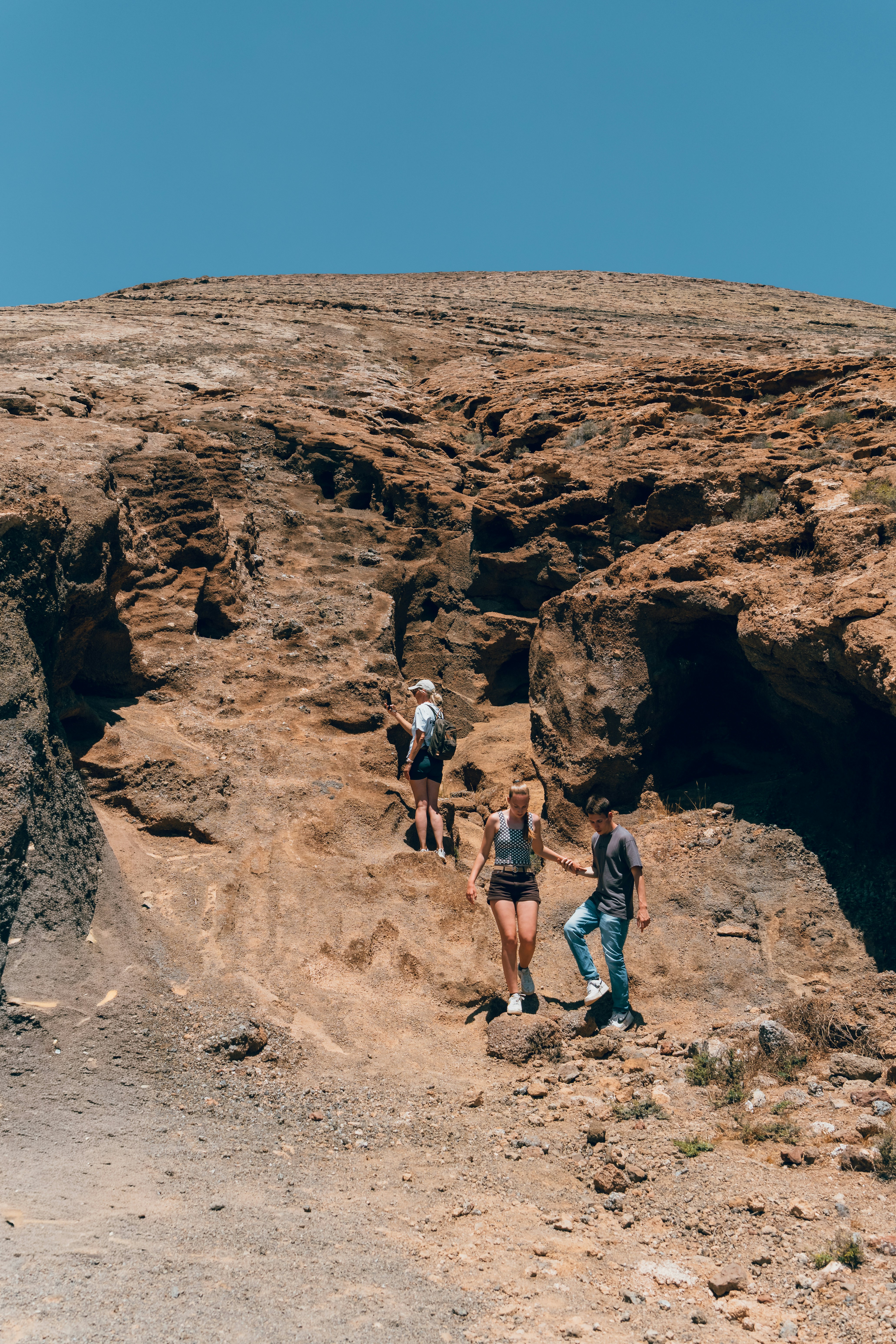 Trekkers Ascend the Rugged Canyon Stairway Beneath a Clear Desert Sky