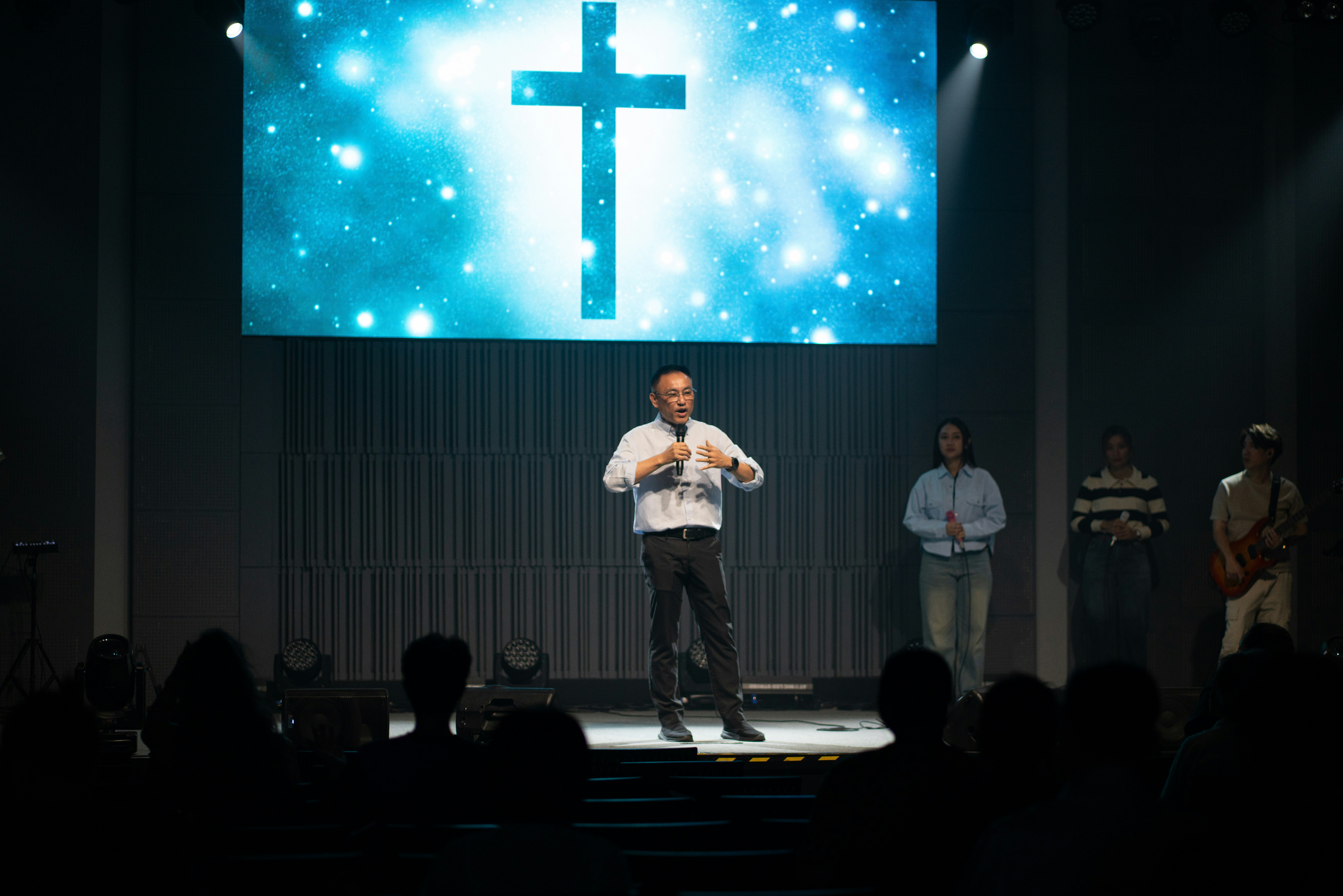 Stage Sermon: Spotlight on the Speaker Under a Cosmic Cross