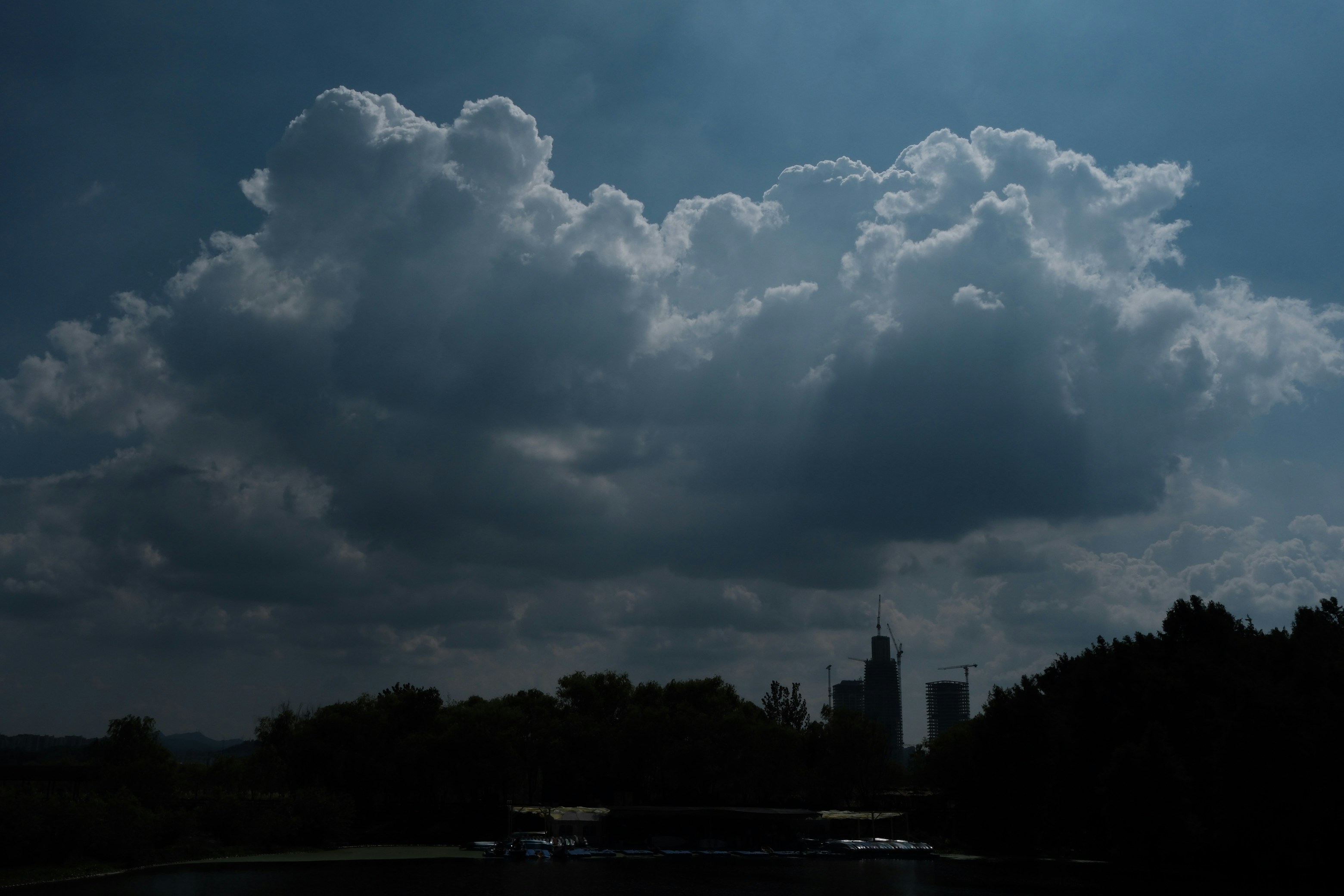 City Skyline Silhouette Beneath Billowing Clouds at Dusk