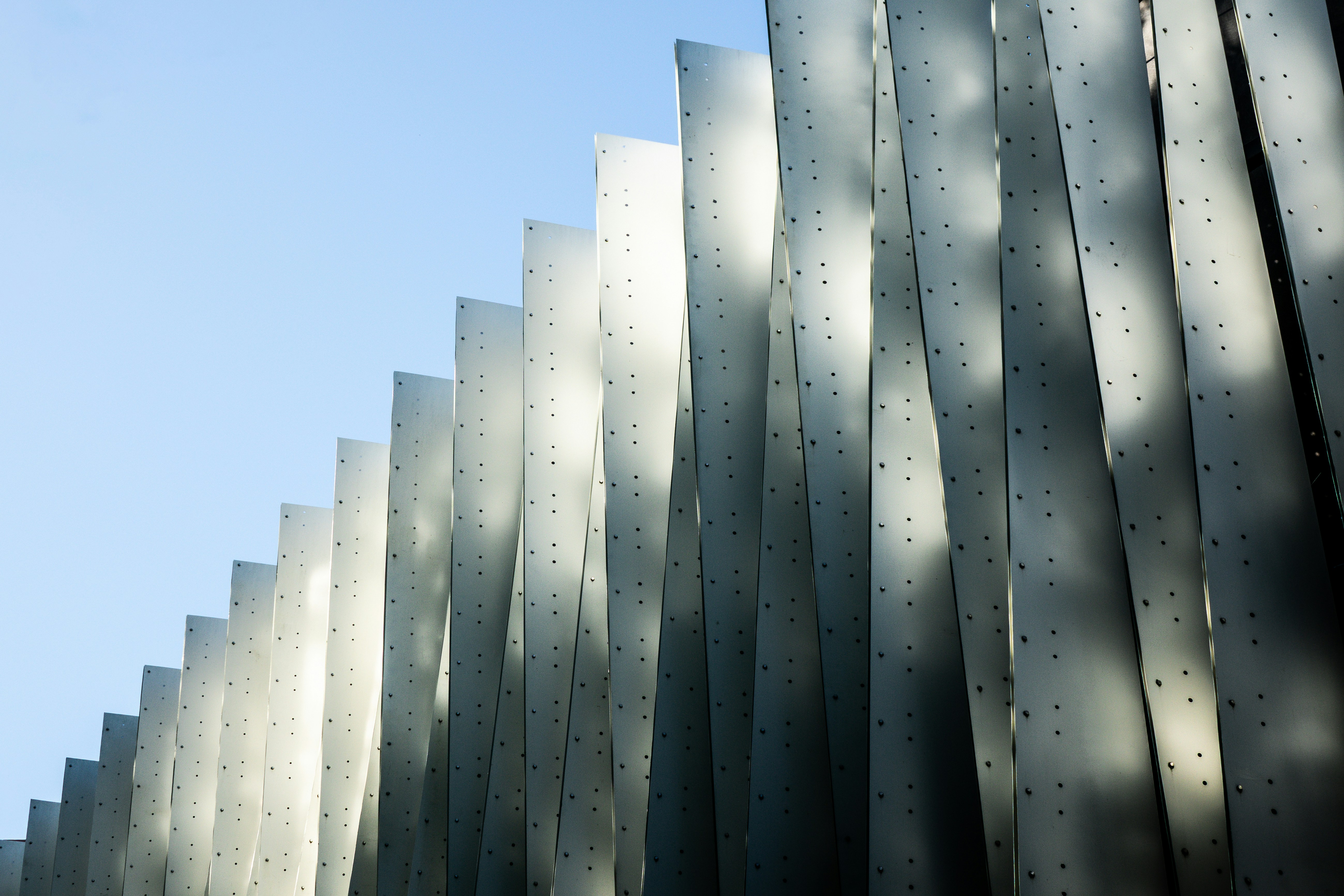 Angled Facade: Repeating Steel Ribs Against a Clear Sky