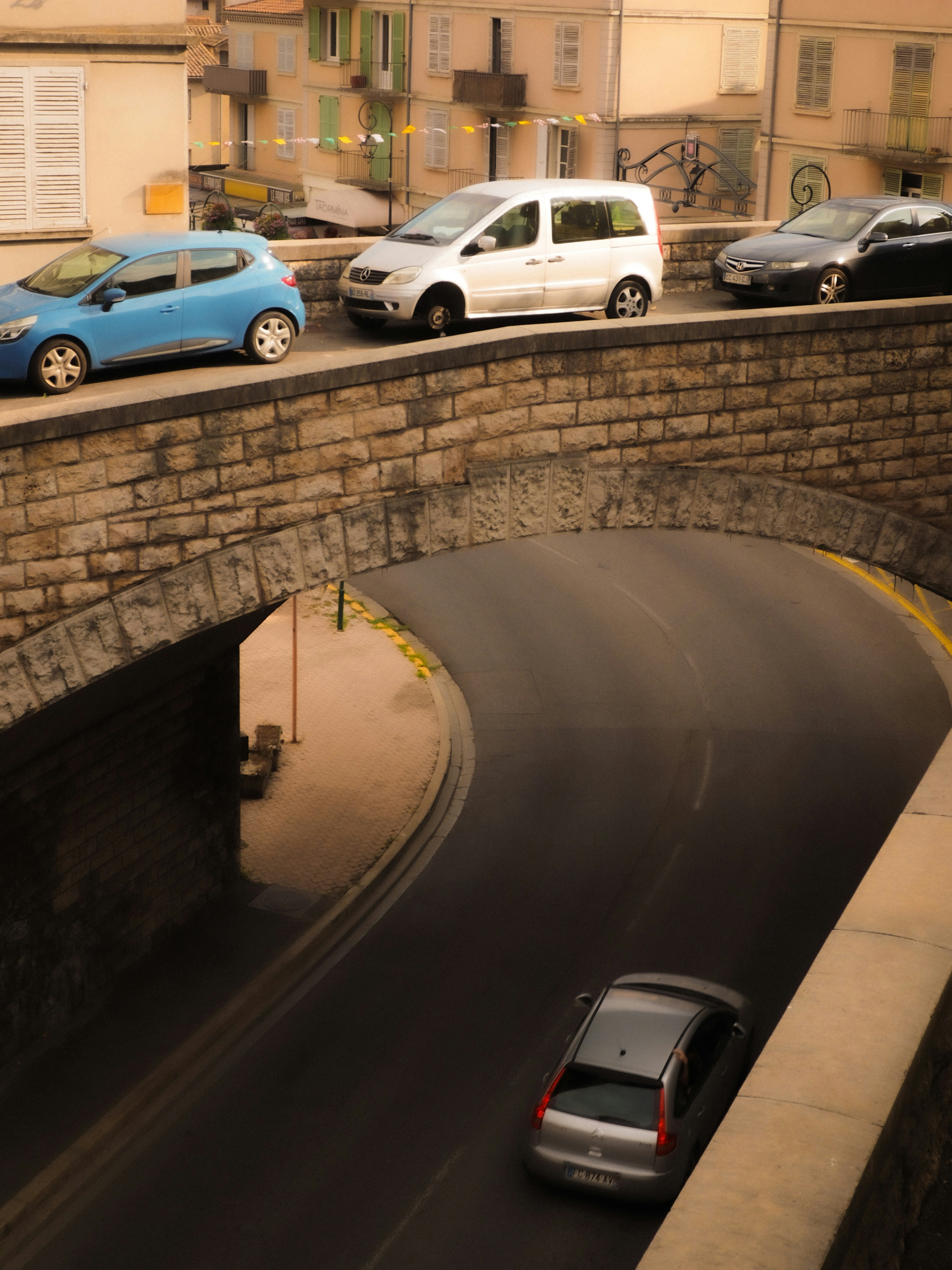 Bridging the Street: Cars, Arch, and a Wrapping Curve