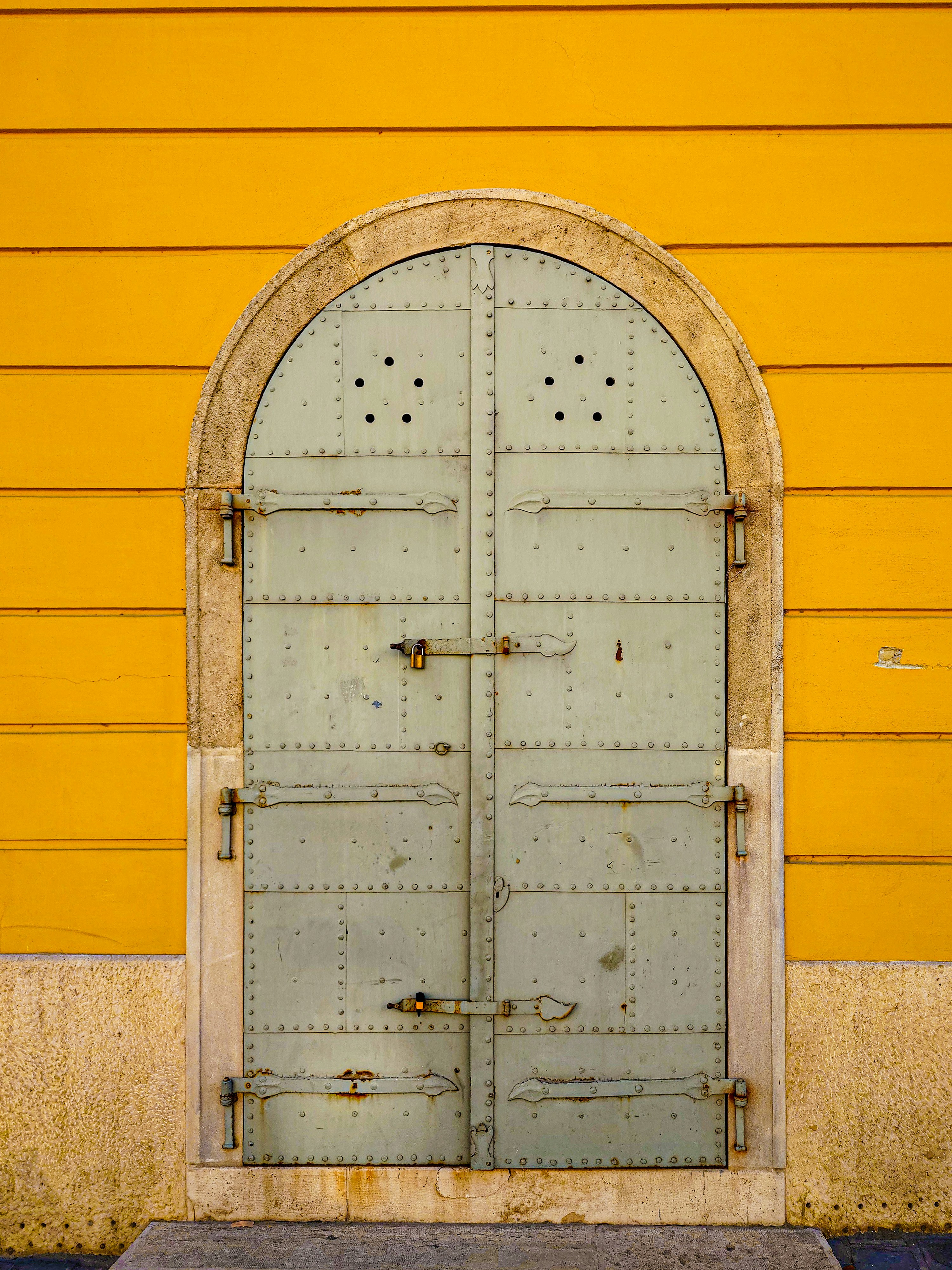 Sunlit Archway: A Pale Door Framed by Golden Walls