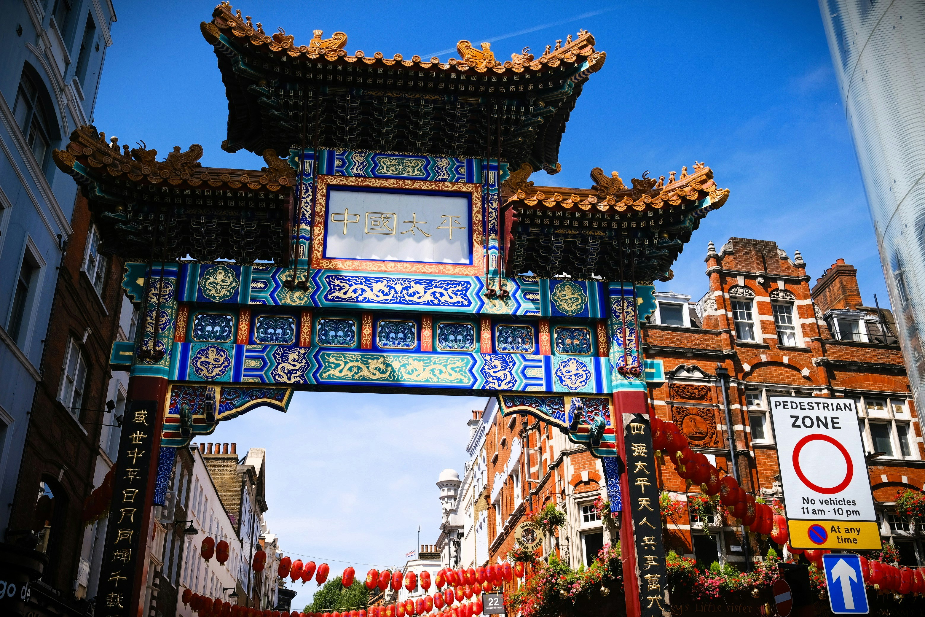 Gateway to Lantern-Lit Streets: A Chinatown Arch Framed by Urban Facades