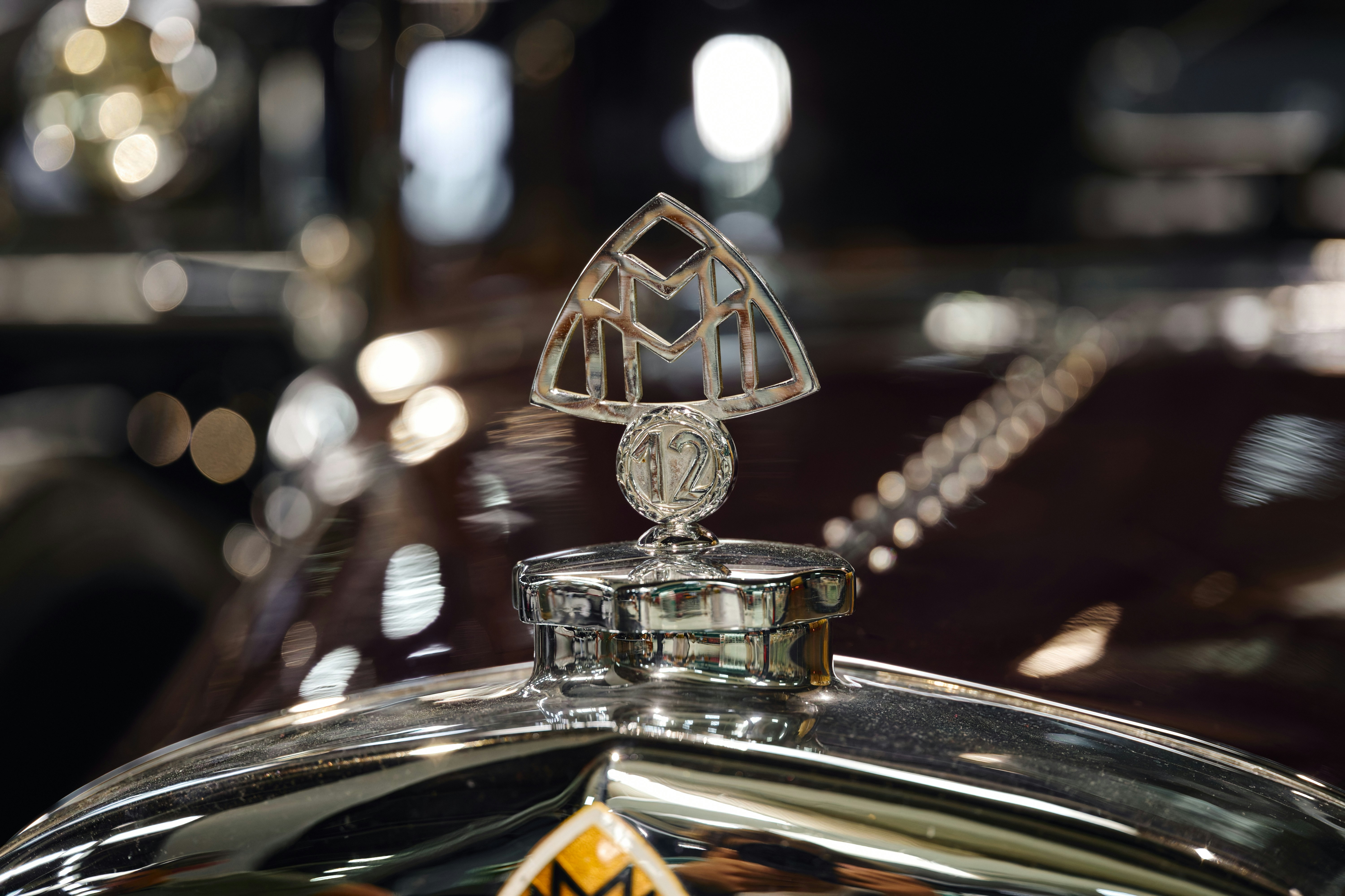 Ornate hood ornament crowned by chrome reflections