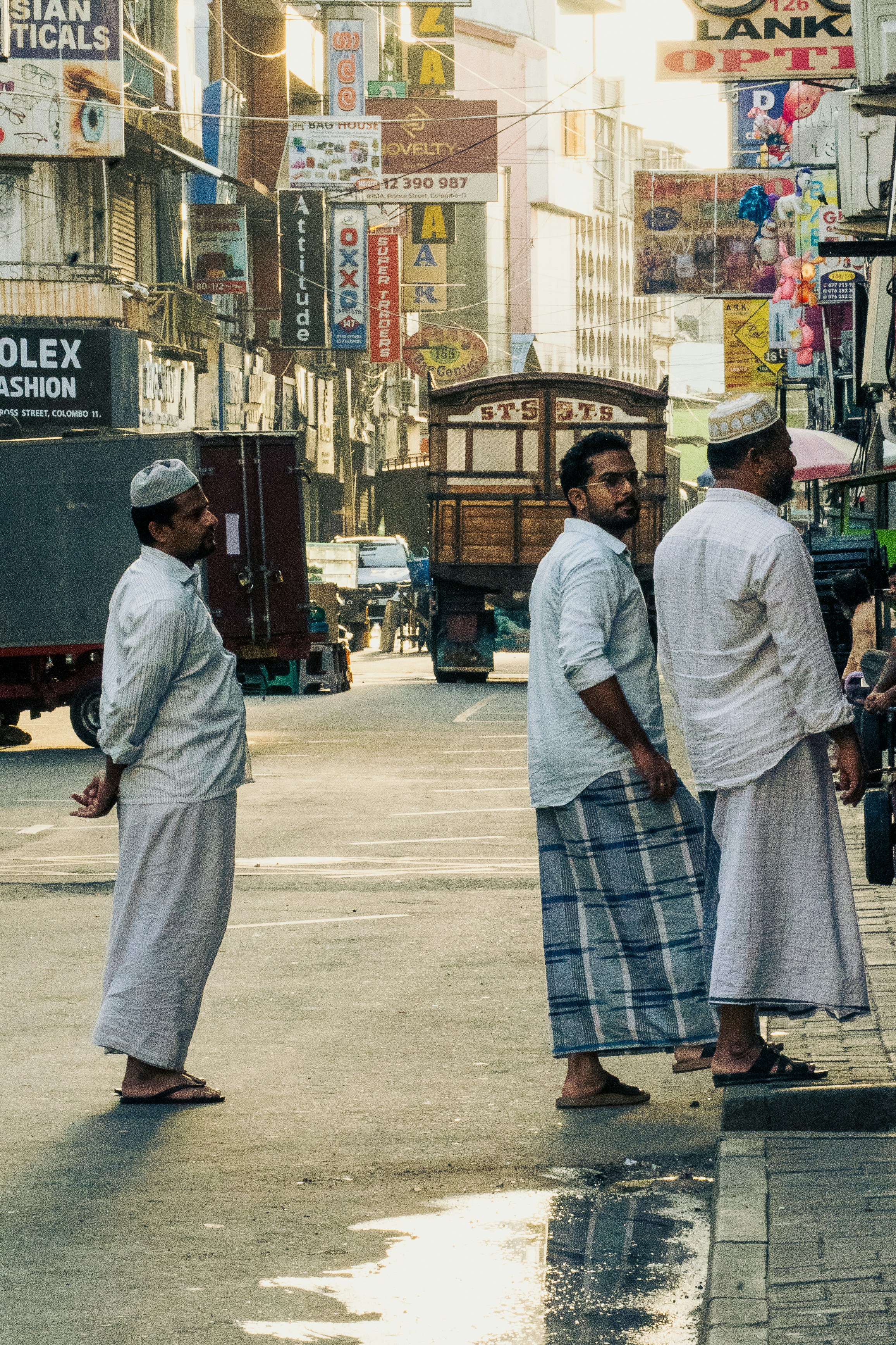 Midstreet Convergence: Three Gentlemen in White on a Sunlit Passage