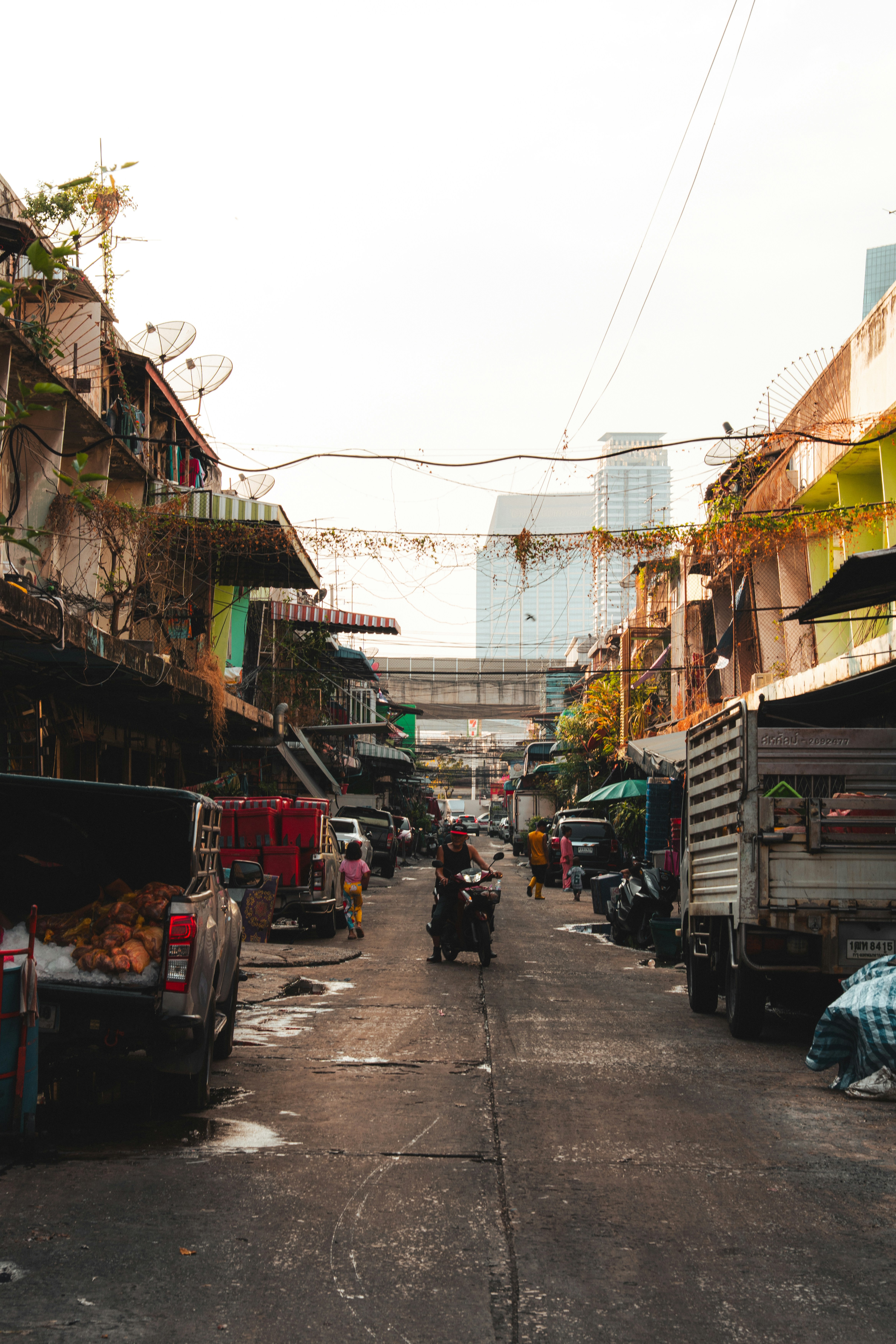 Urban Market Alley at Dusk: A Street Unfolds Under Wiring and Life
