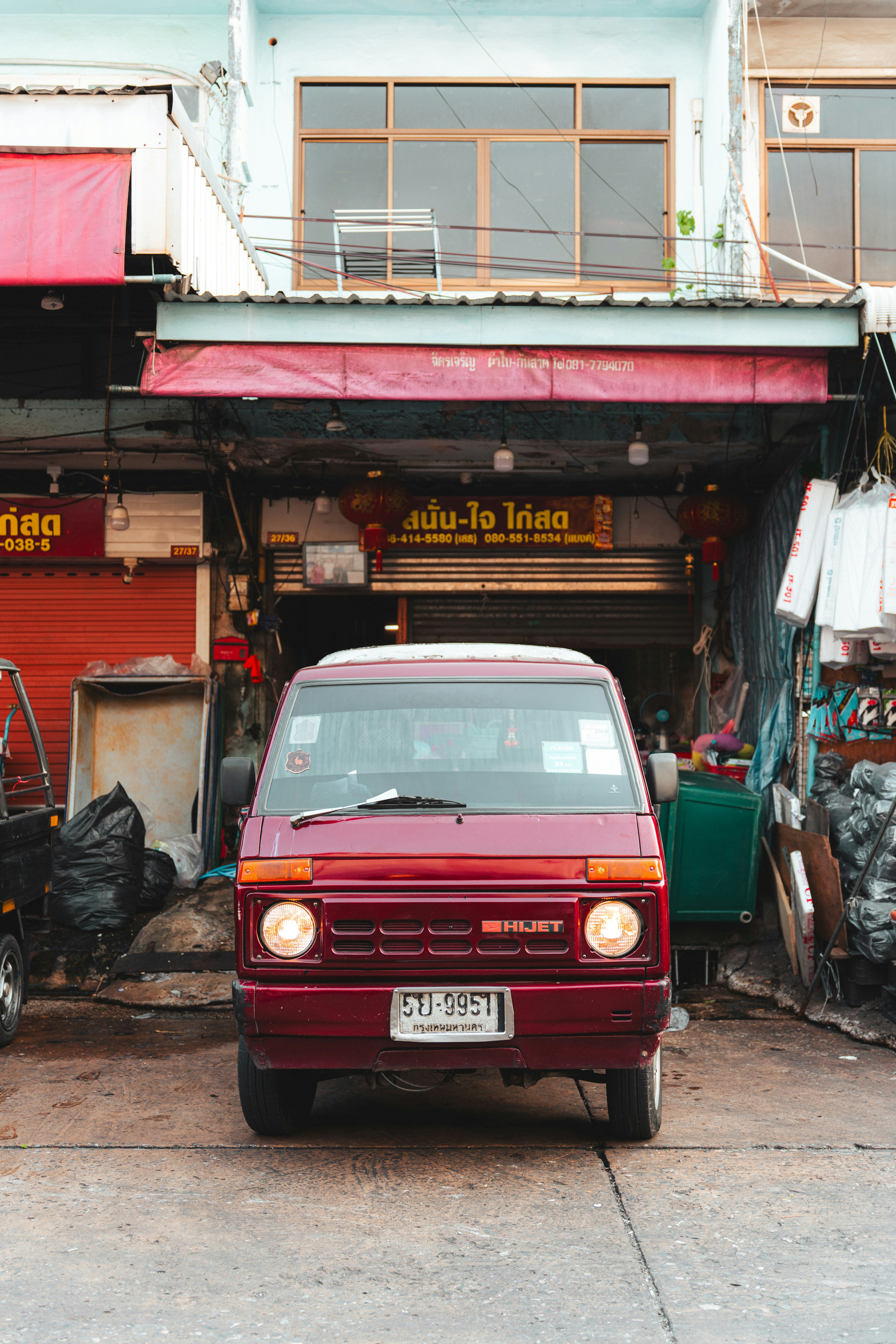 Red van at a bustling street shopfront