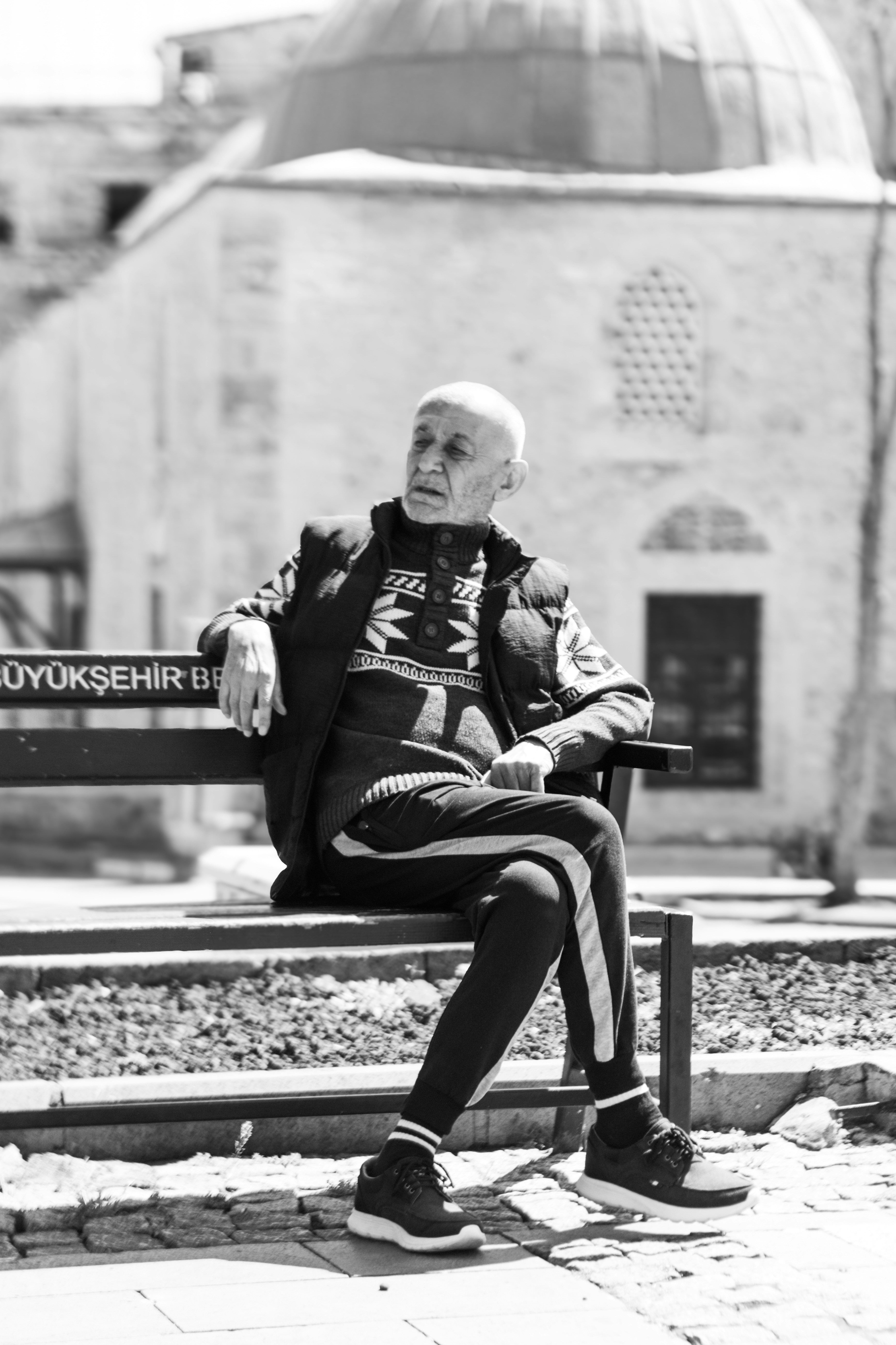 Elder on a Bench: Quiet Confidence Beneath a Historic Dome