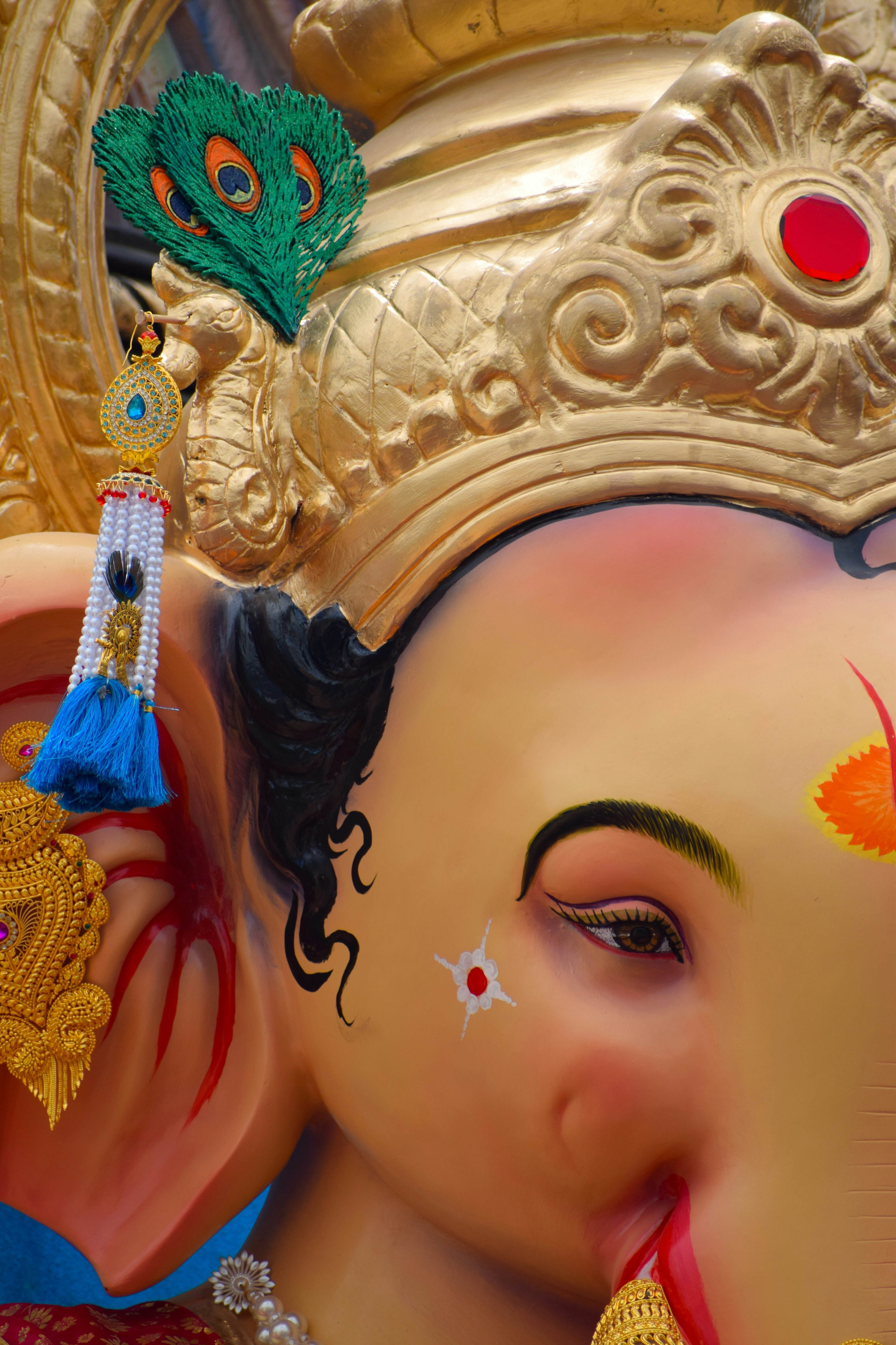 Golden Ganesh Portrait: Vibrant Ceremonial Face with Peacock Adjunct