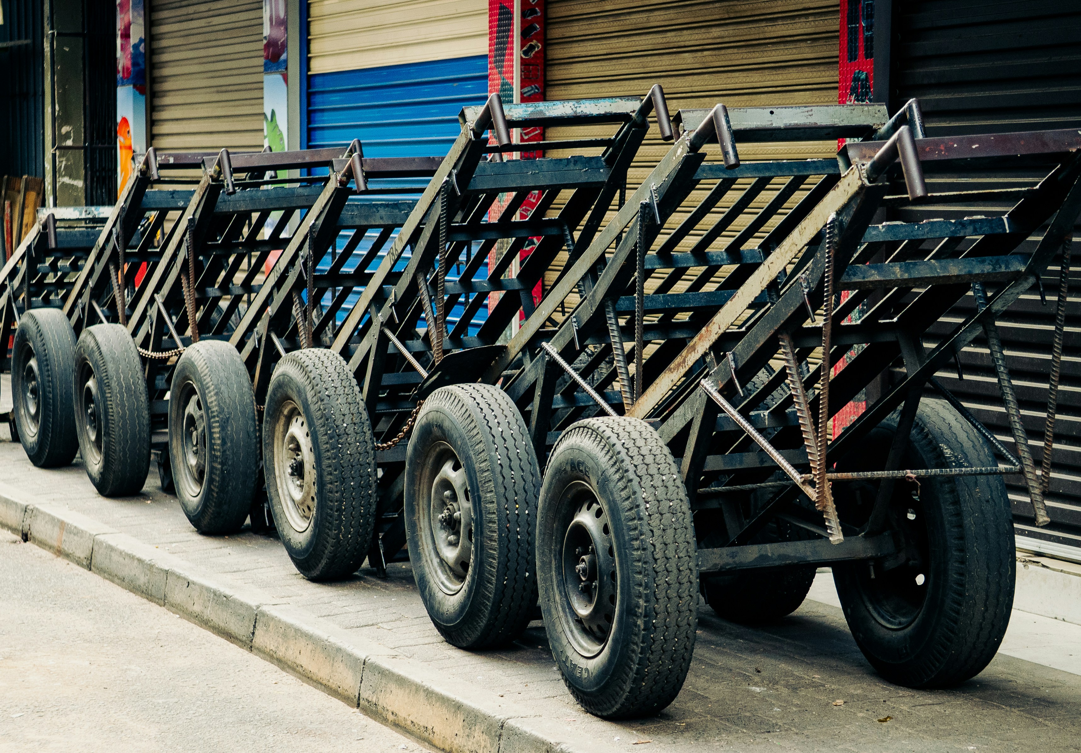 Tire Trains: A Row of Industrial Wagons Slotted Along the Curb