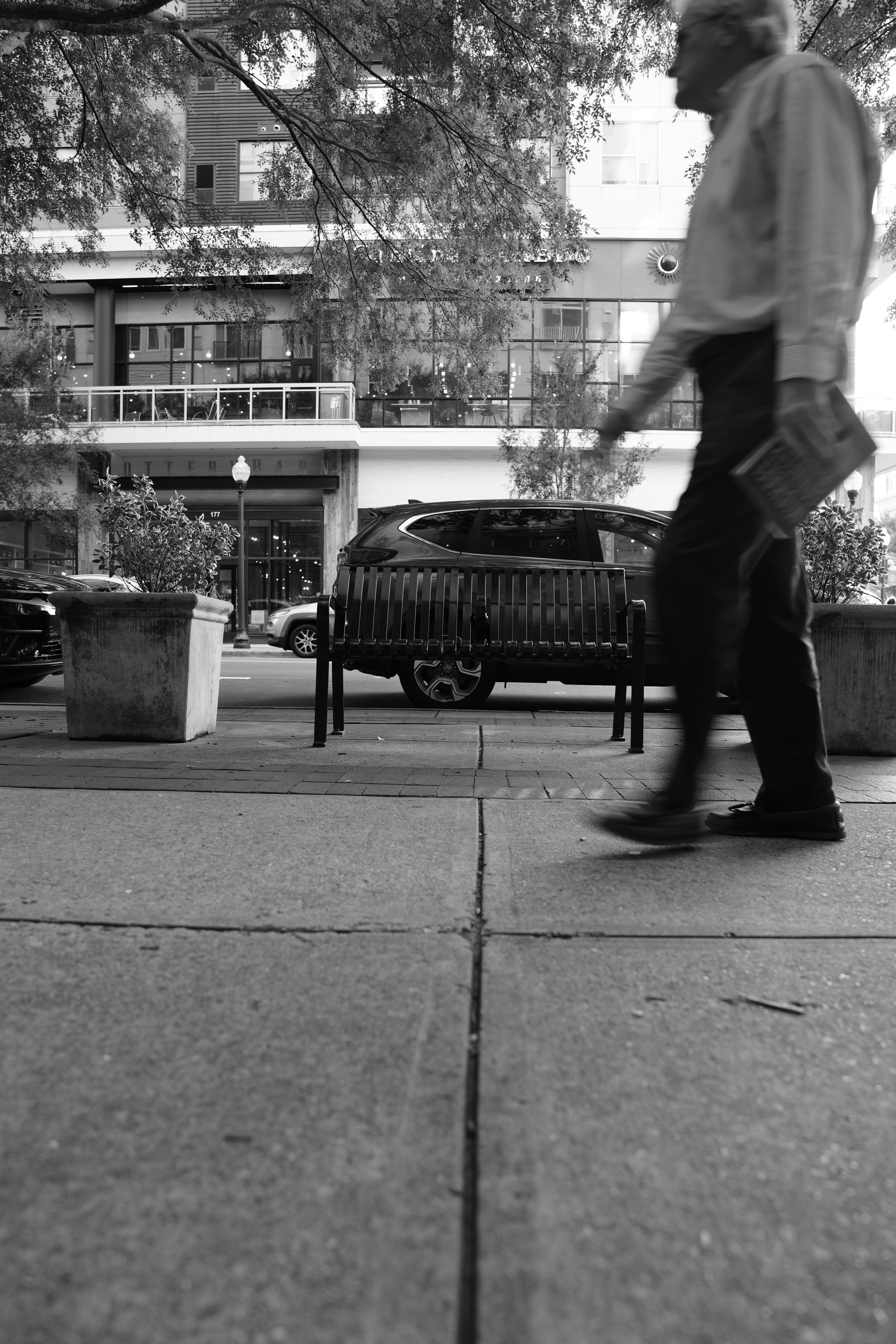 Footstep in Focus: A Moving Figure Past a Parked Bench