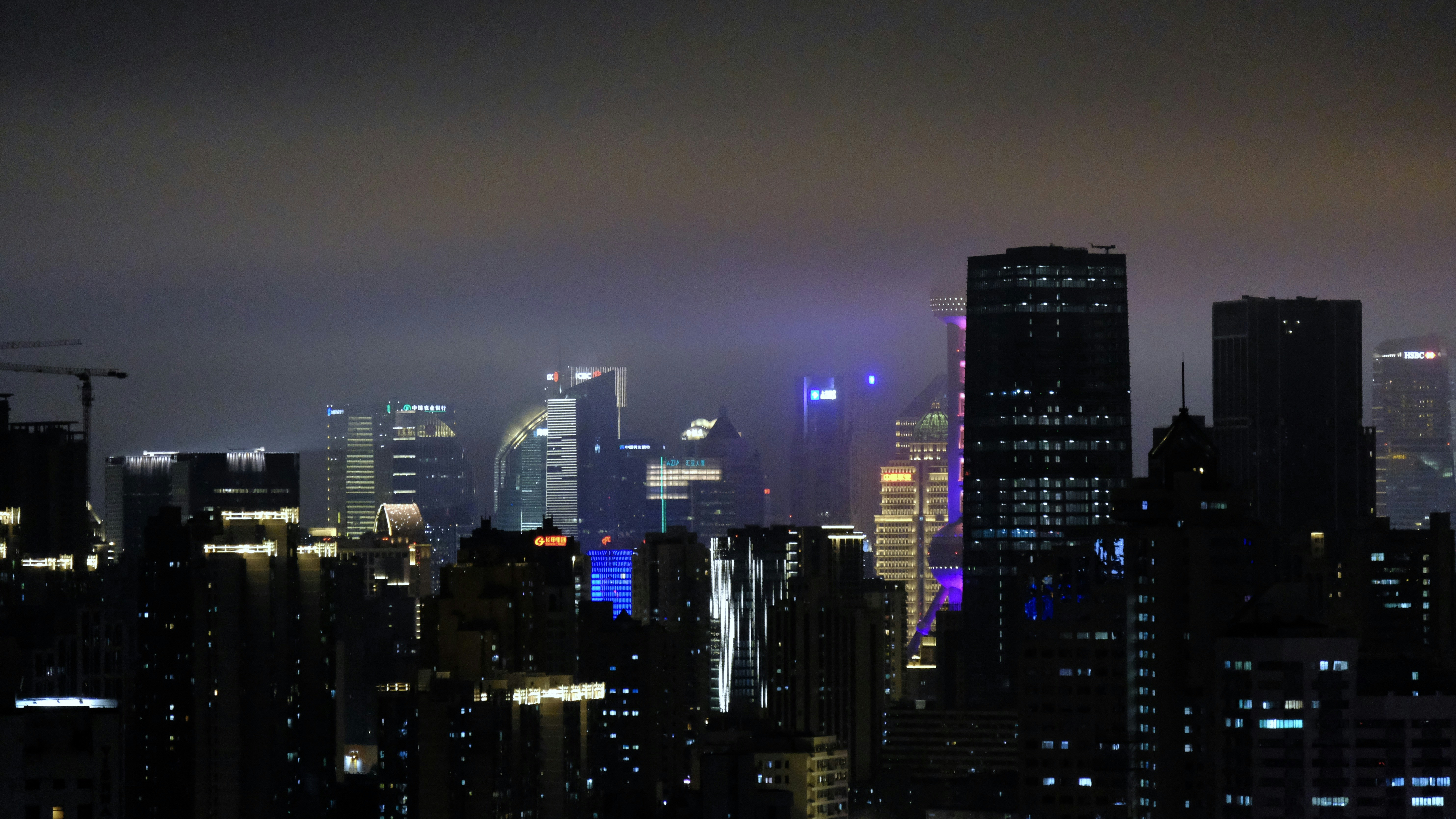 The illuminated skyline of Shanghai at night with the Oriental Pearl Tower visible.