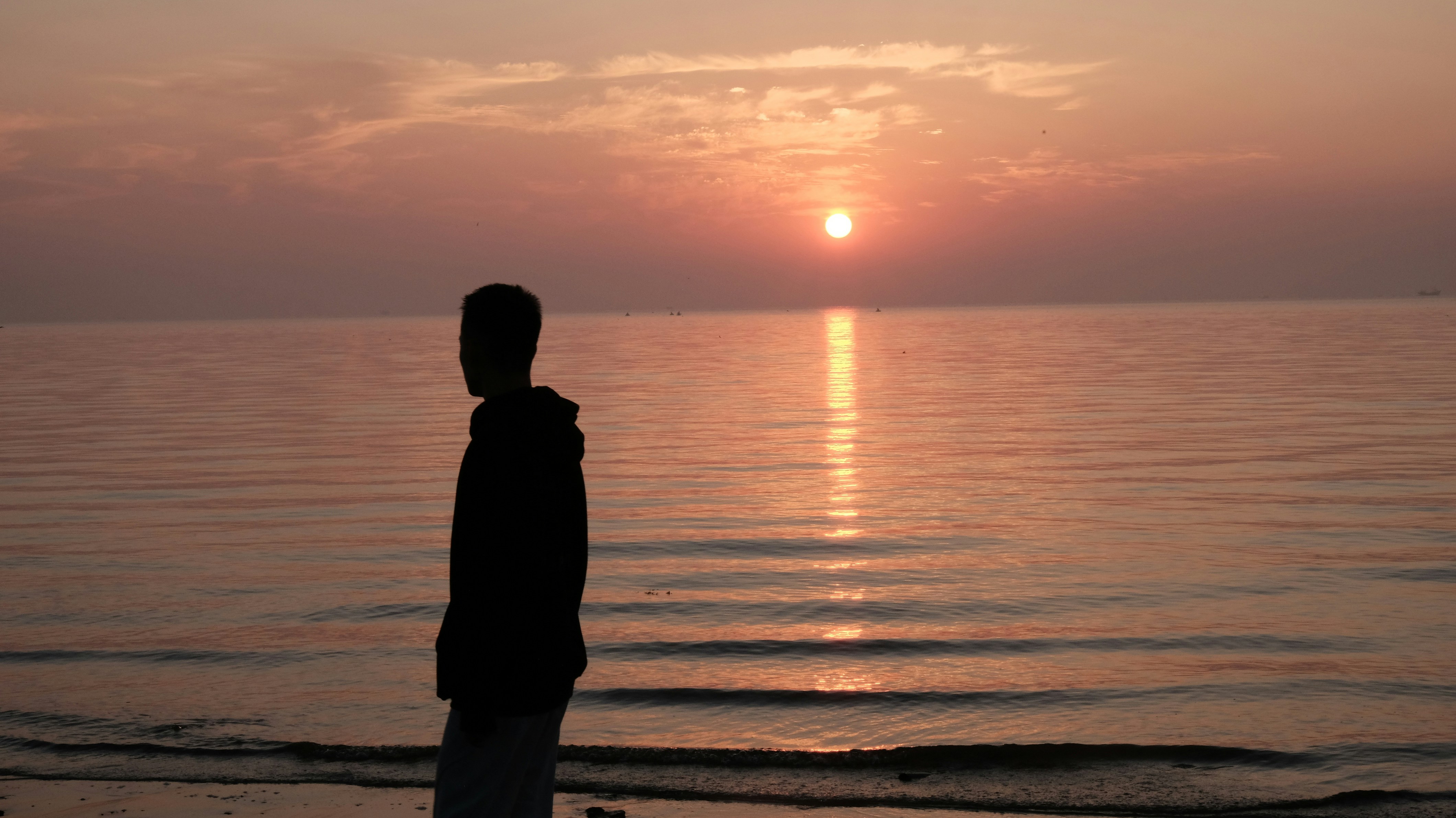 Solitary silhouette against a crimson horizon at tidal dusk