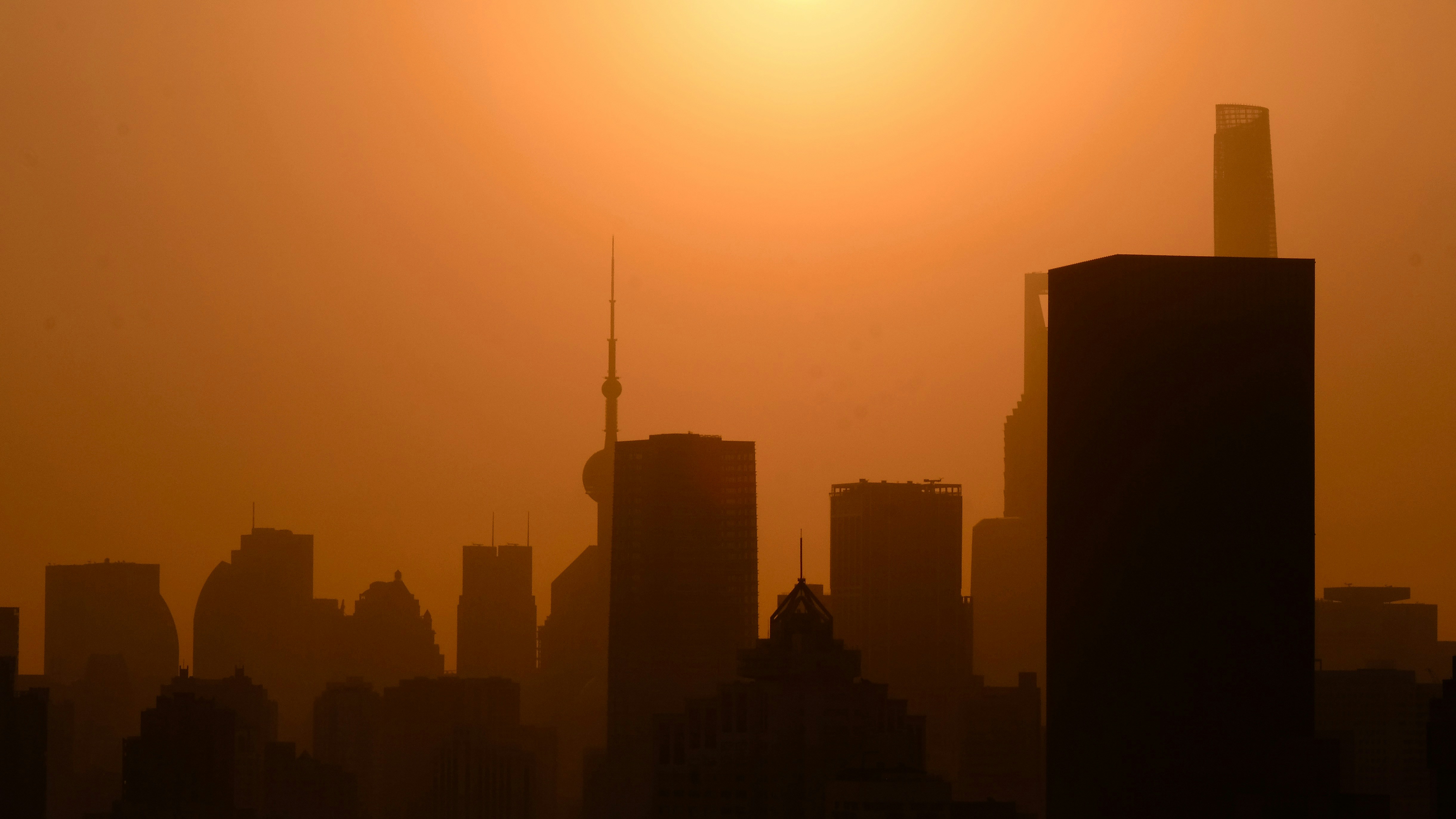 Urban silhouettes at sunset: Tokyo-like skyline in amber haze