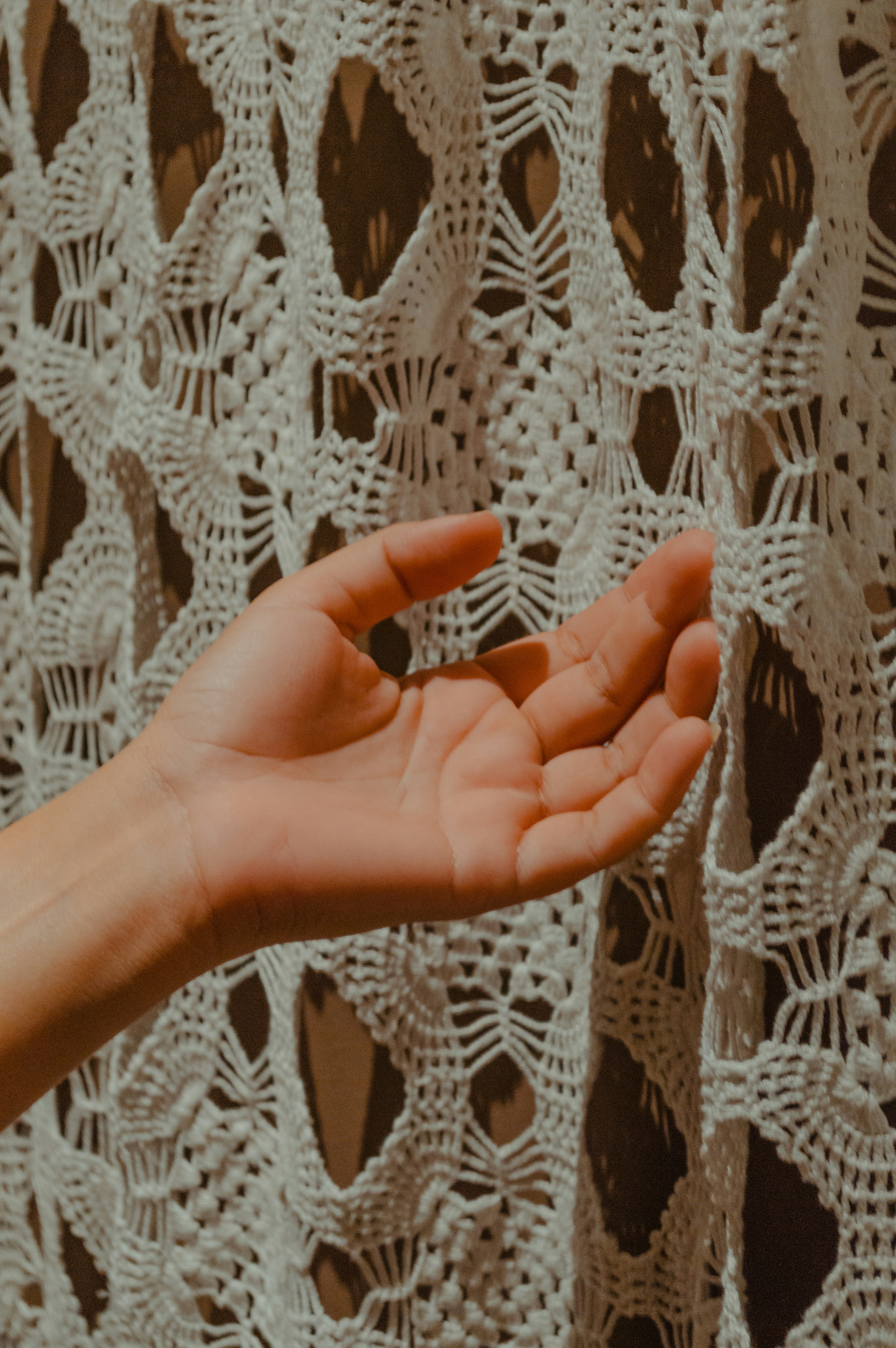 Careful Hands Beneath Lace: A Quiet Moment in White Texture