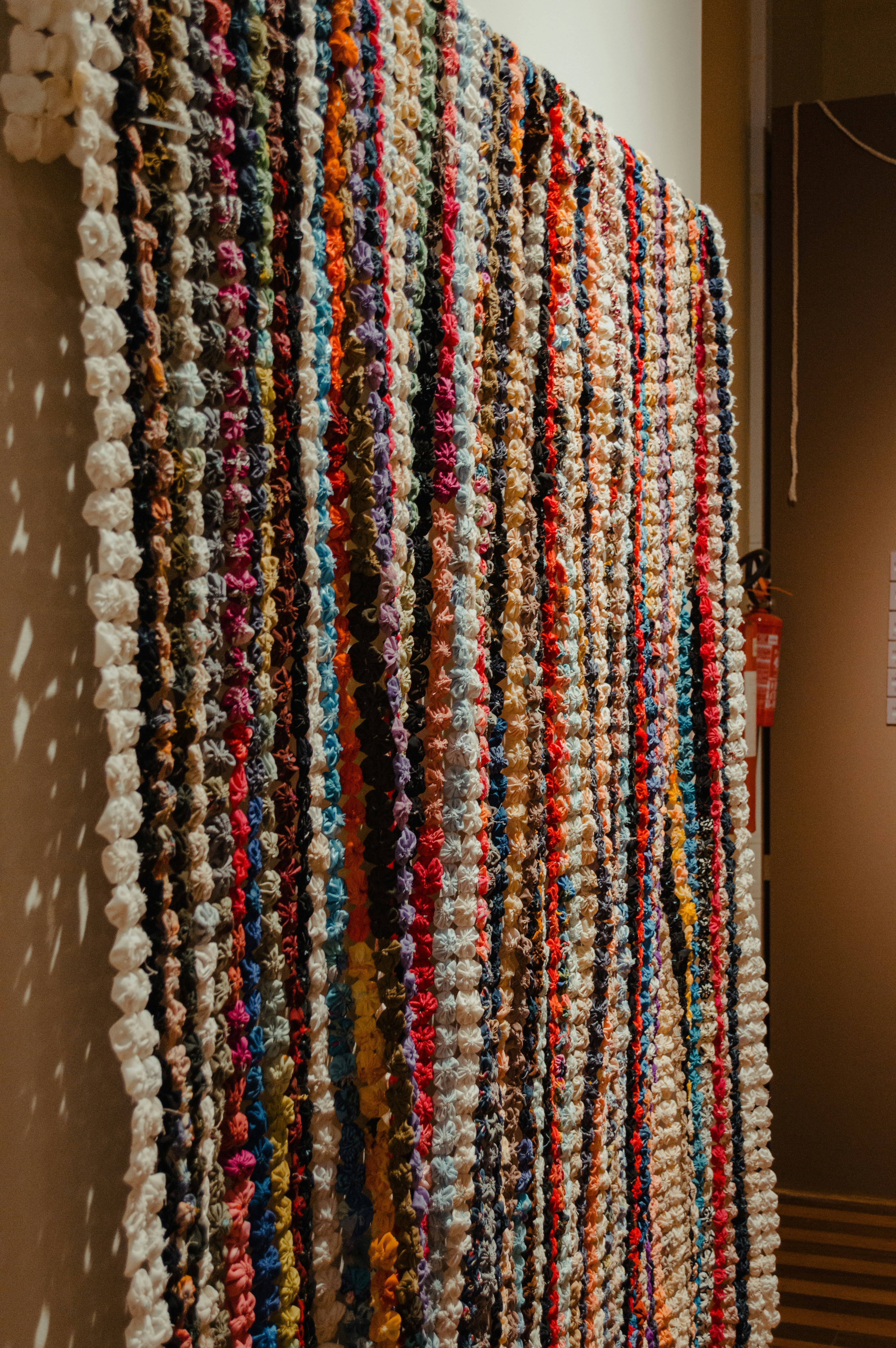A Curtain of Color: Textile Strips Filling a Gallery Corridor