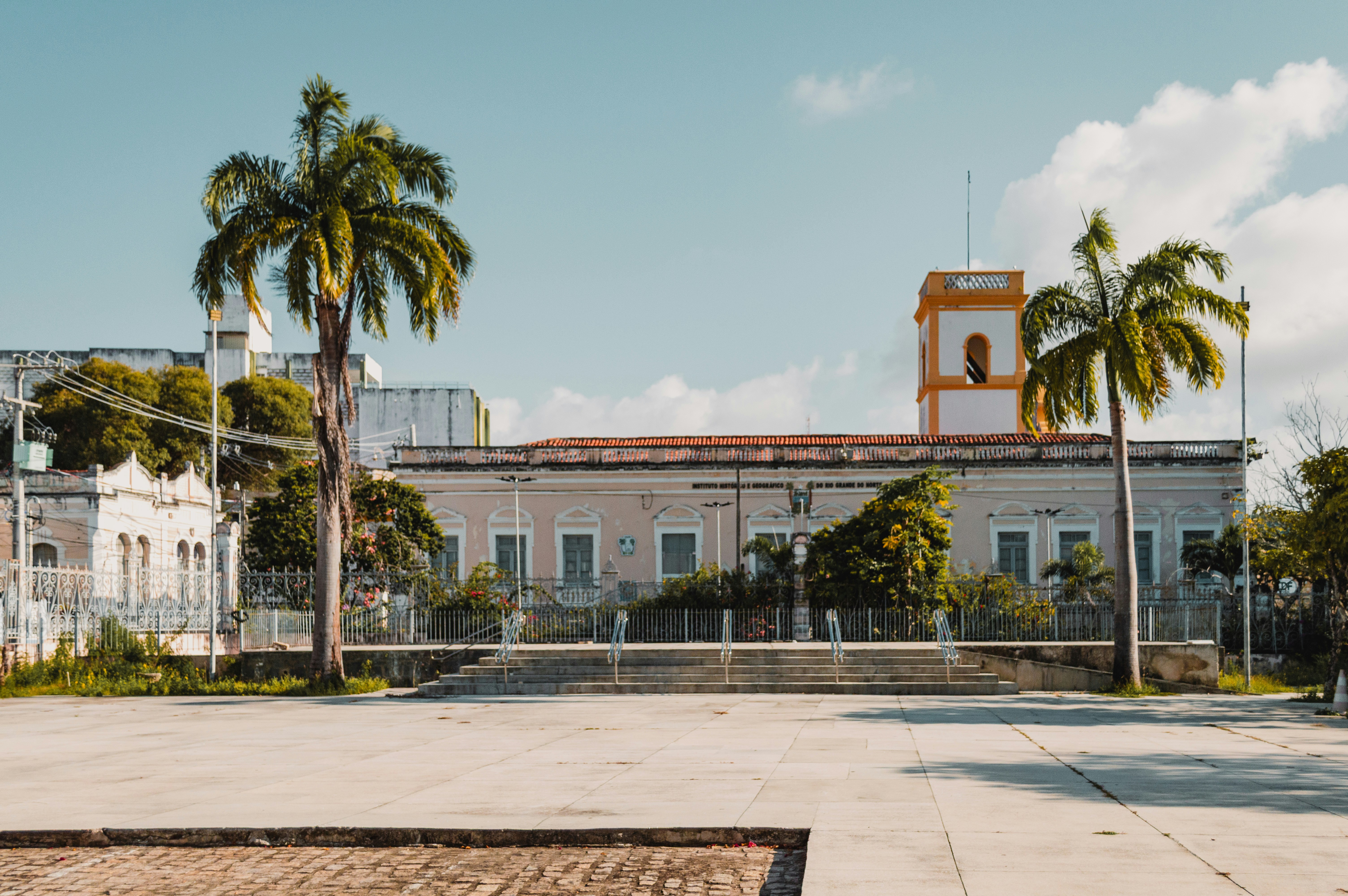 Pastel Plaza with Palm Shadows and Bell Tower