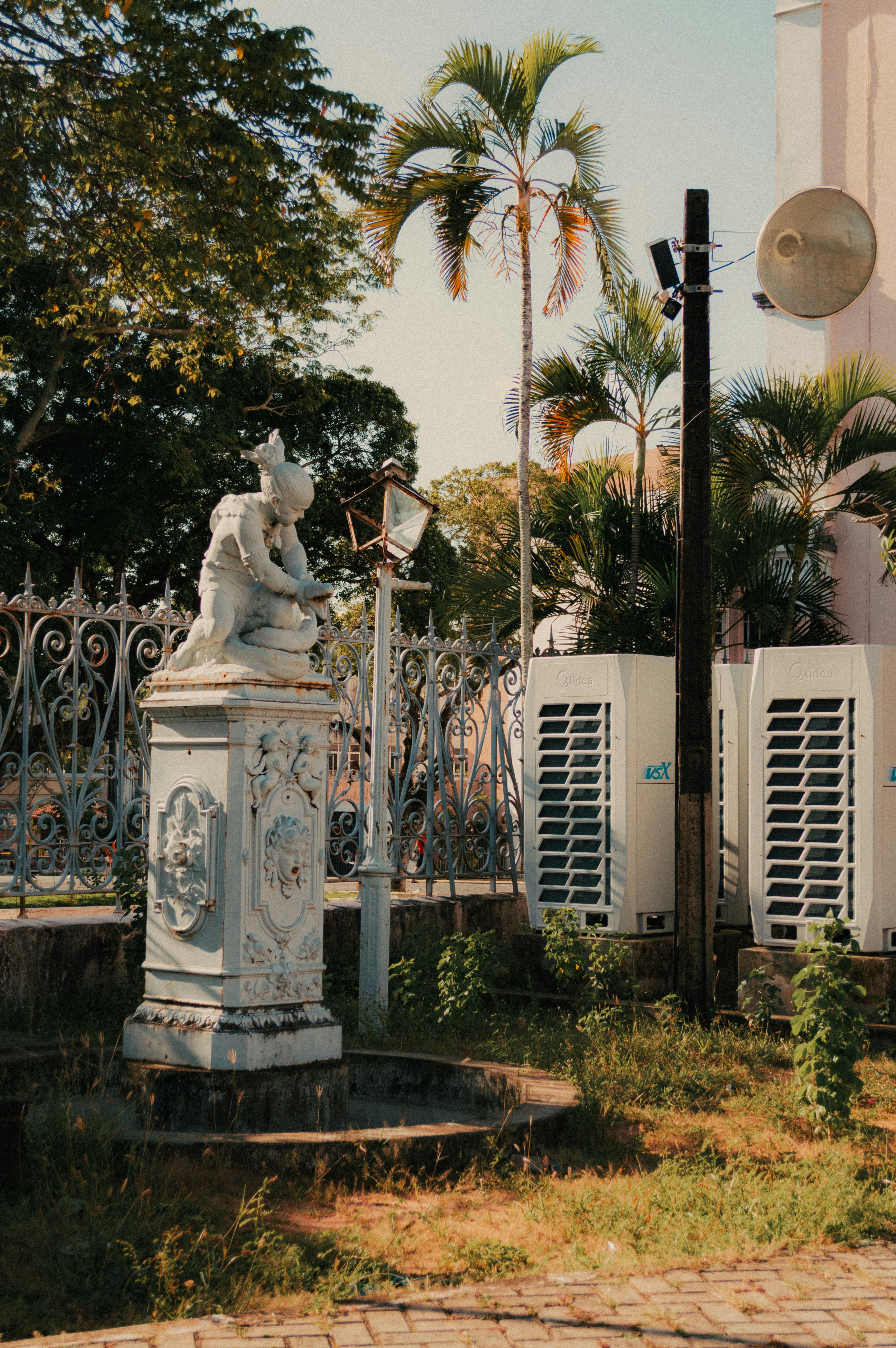 Statue Guarding the Gardens: A Quiet Corner by Air Conditioning