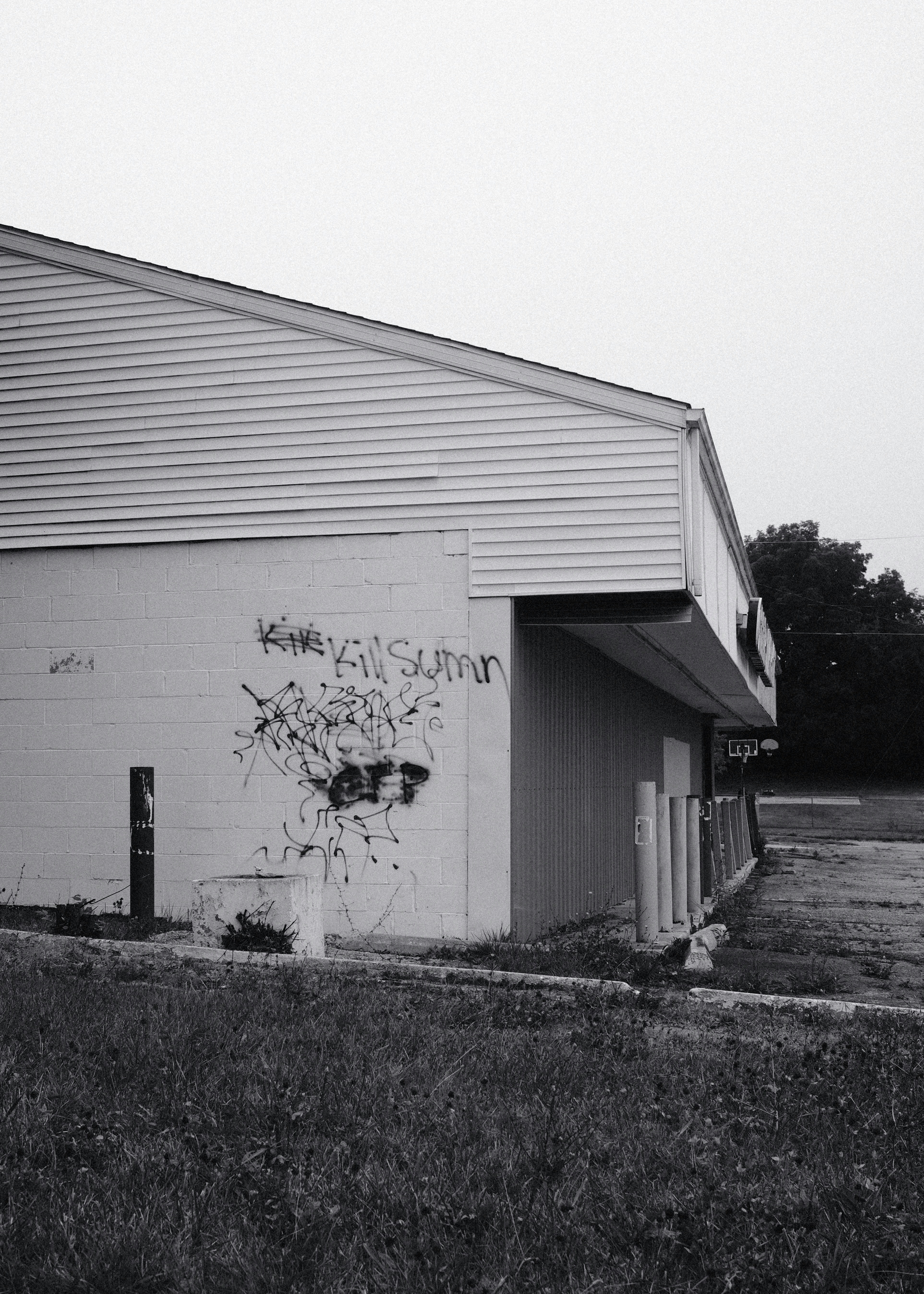 Abandoned Commercial Facade with Graffiti Under Overhang