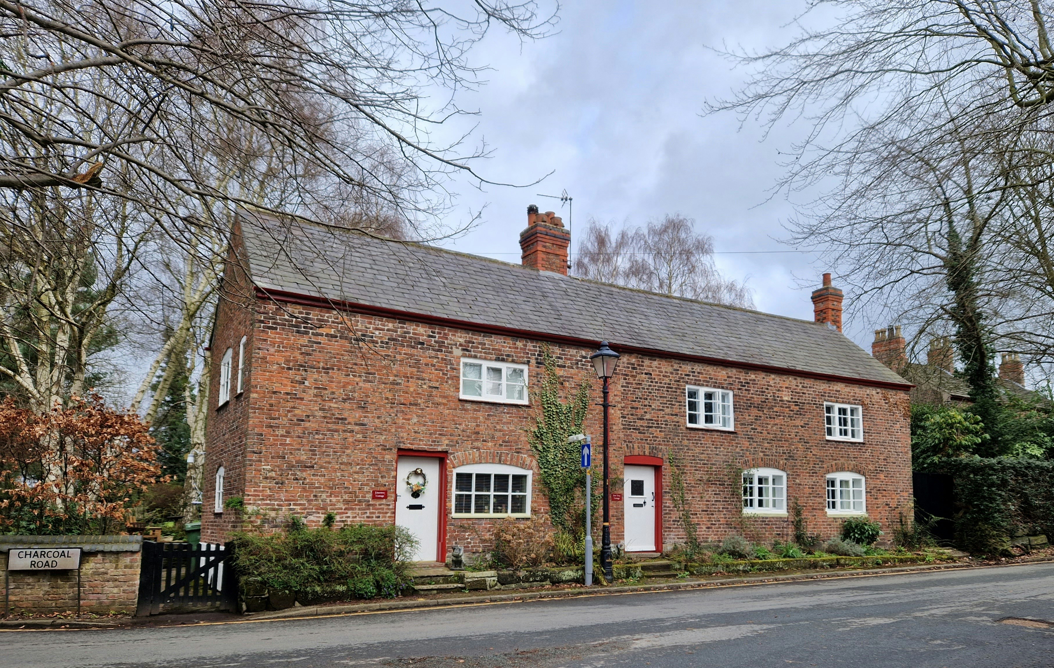 Row of brick cottages under a grey sky