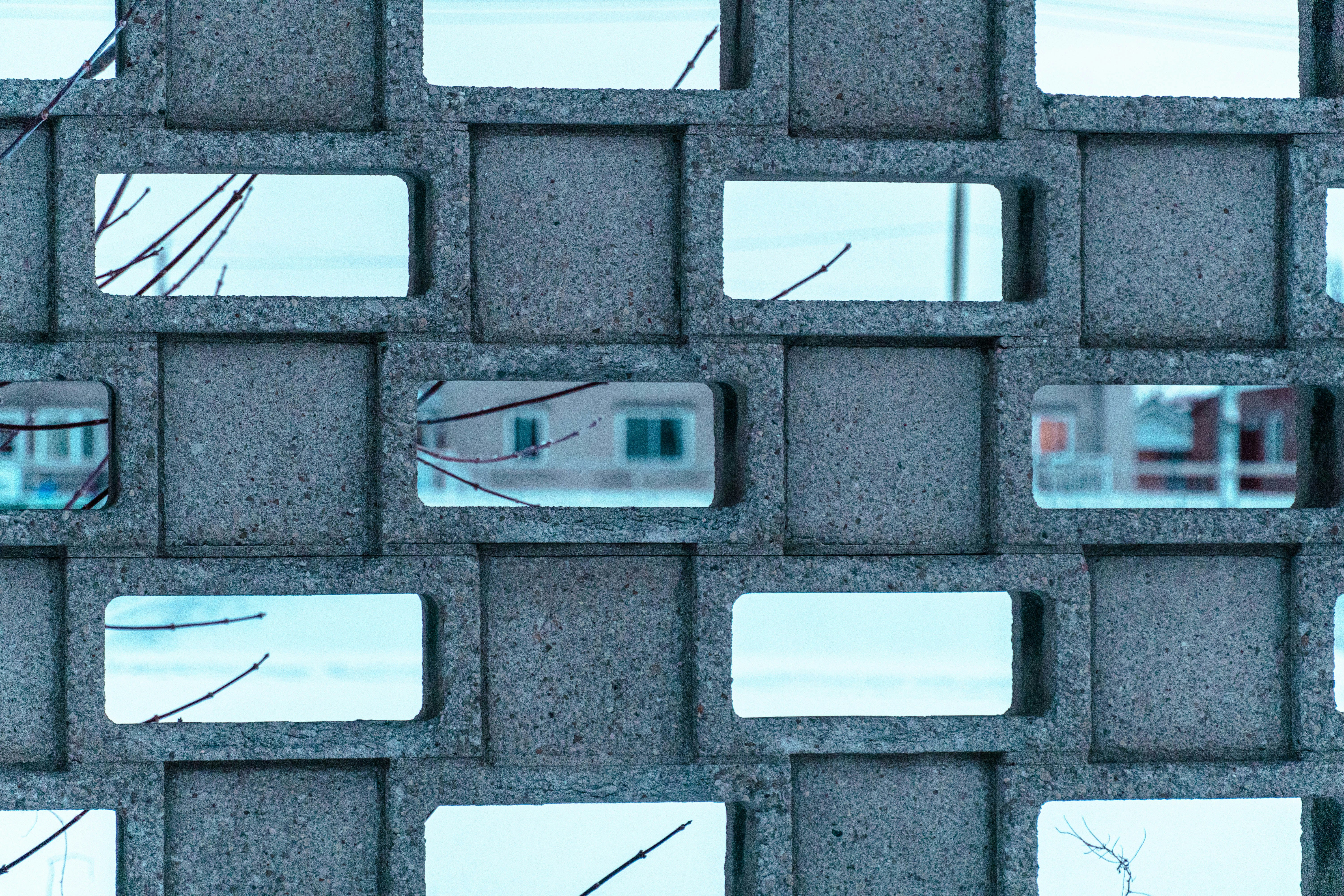 Concrete Grid Echoes: Negative Space Reflections in a Perforated Wall