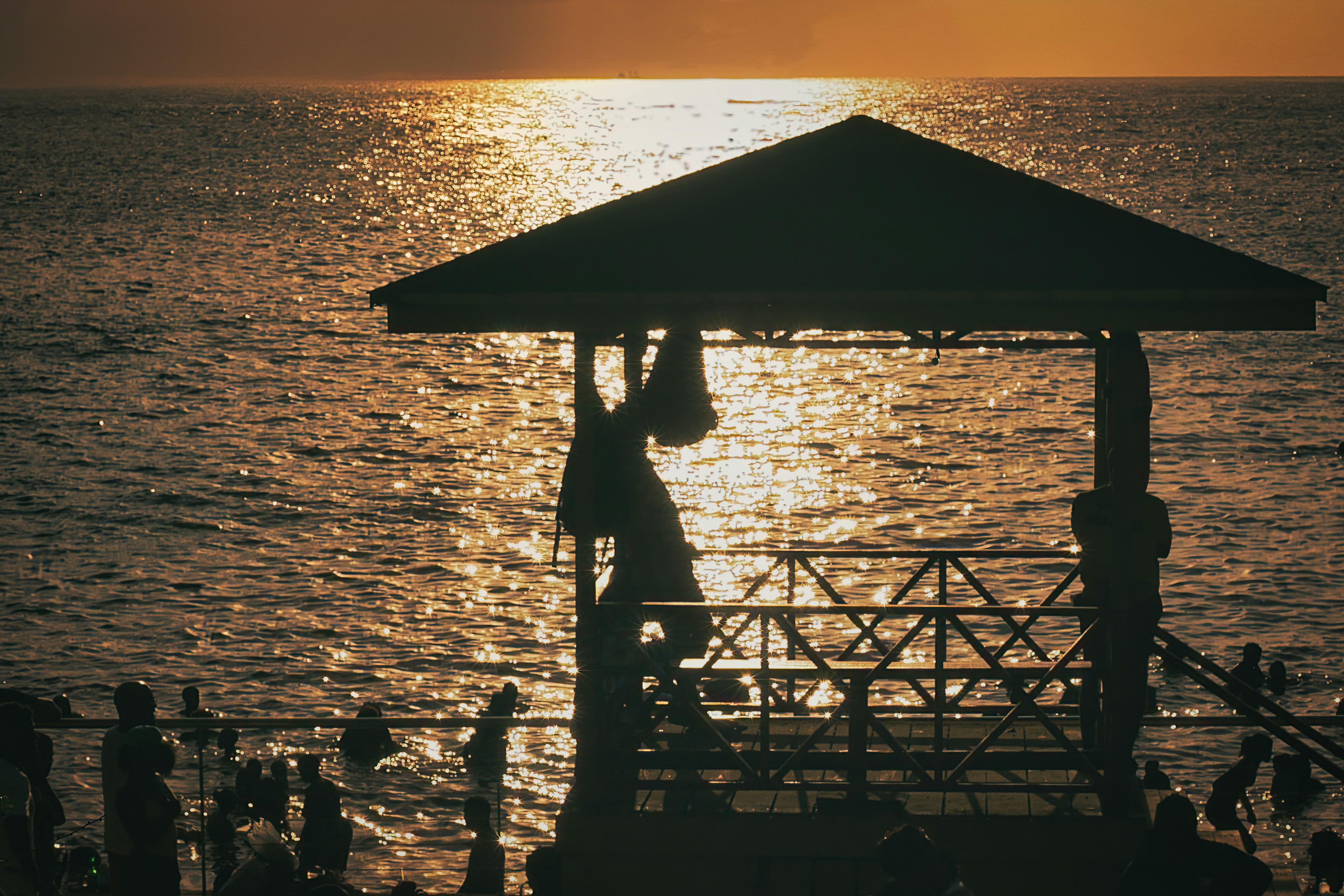Silhouette at Sunset: A Quiet Moment Under the Pier