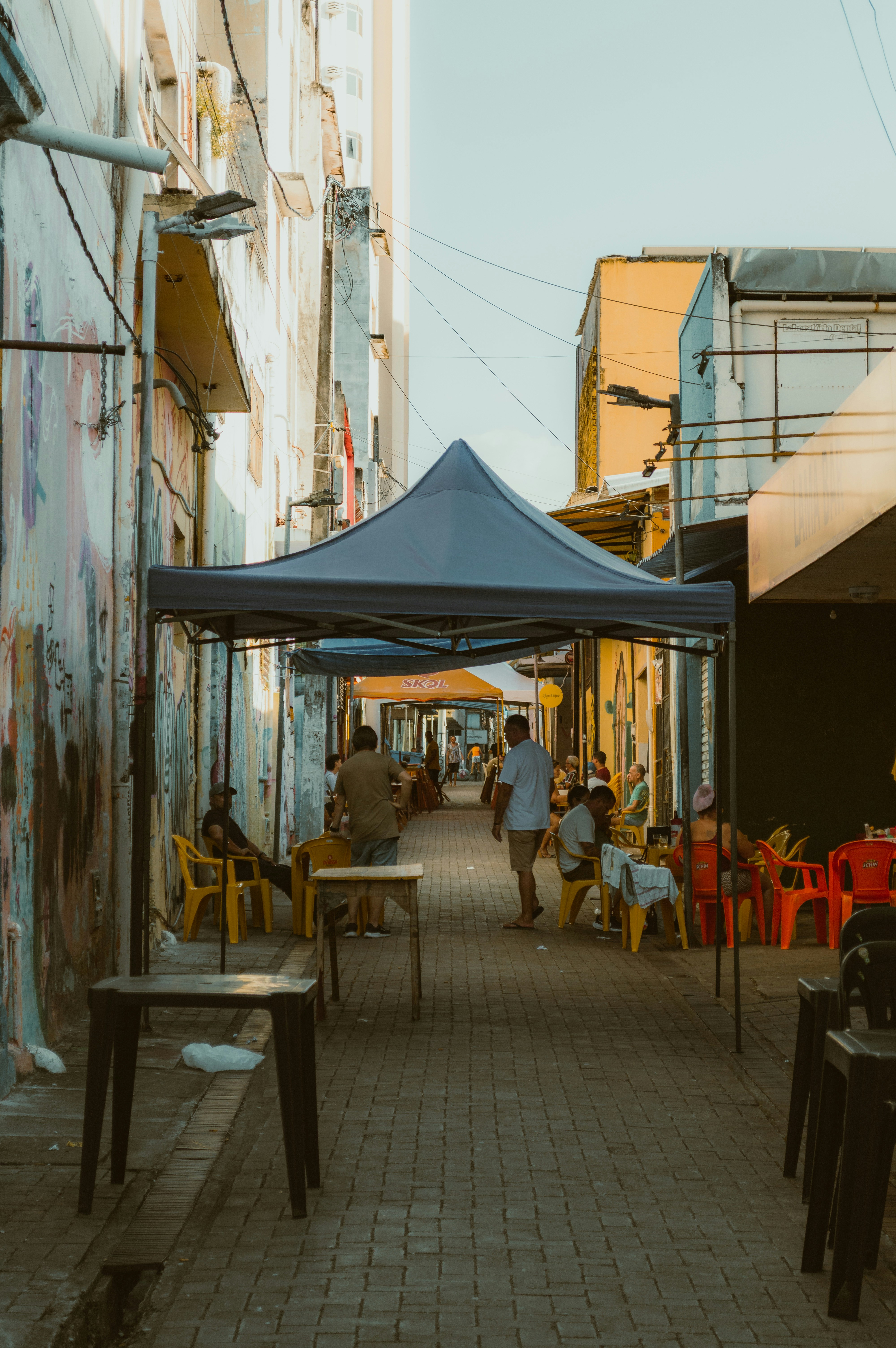 Narrow Street Café Under a Blue Canopy