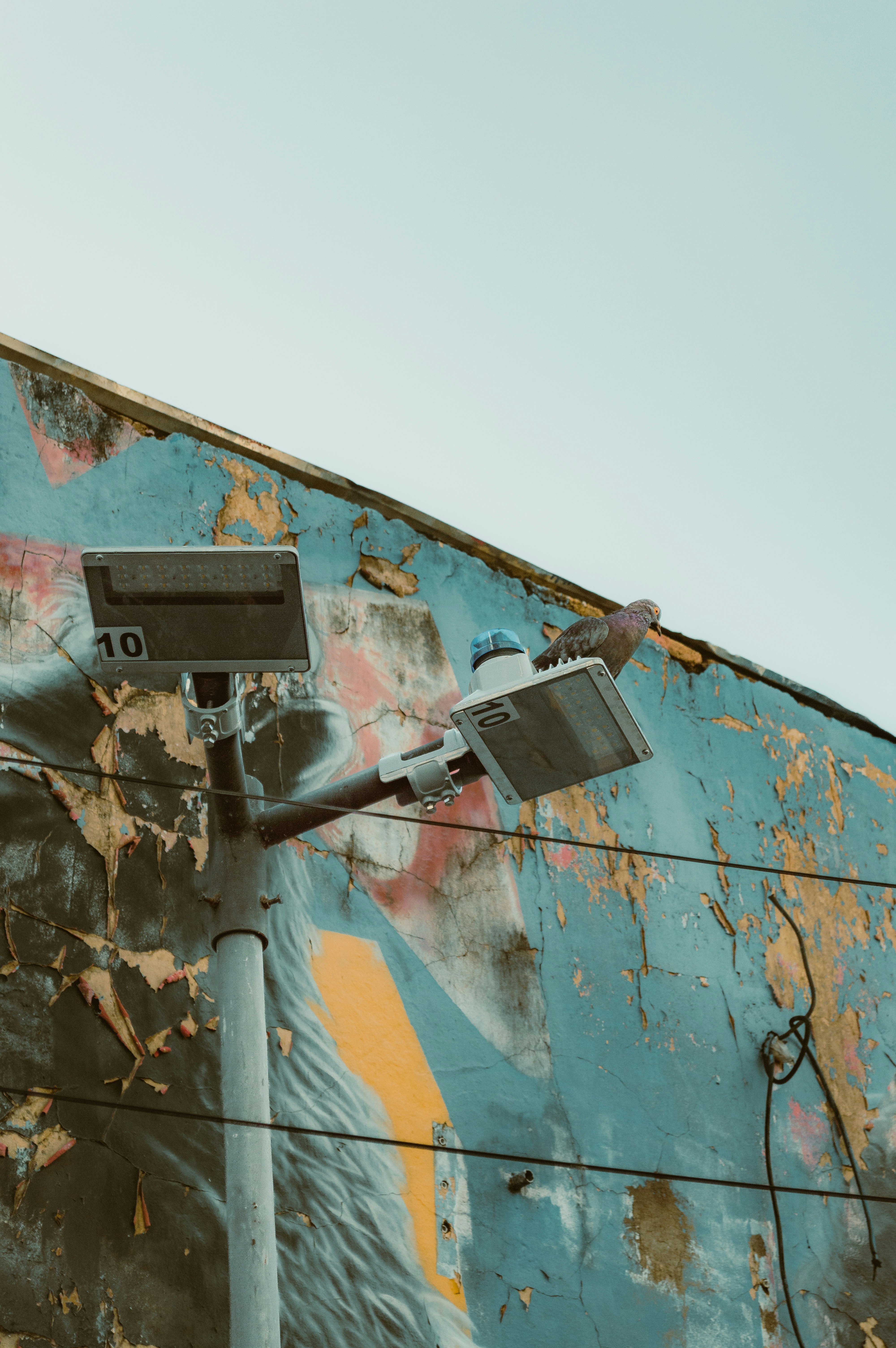 Weathered mural and utility lights on a crumbling wall