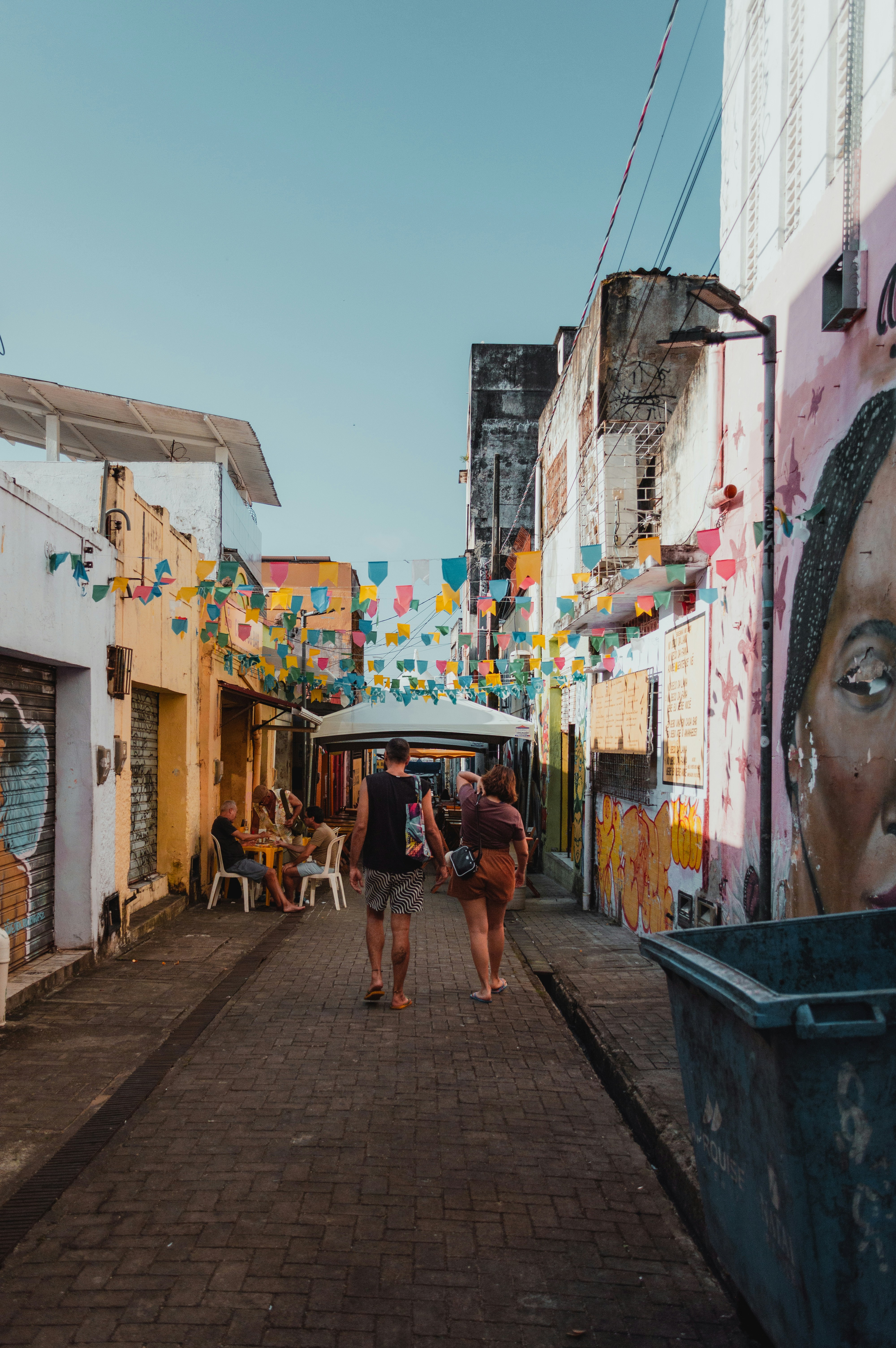 Sunlit Alley Rendezvous under Festive Banners