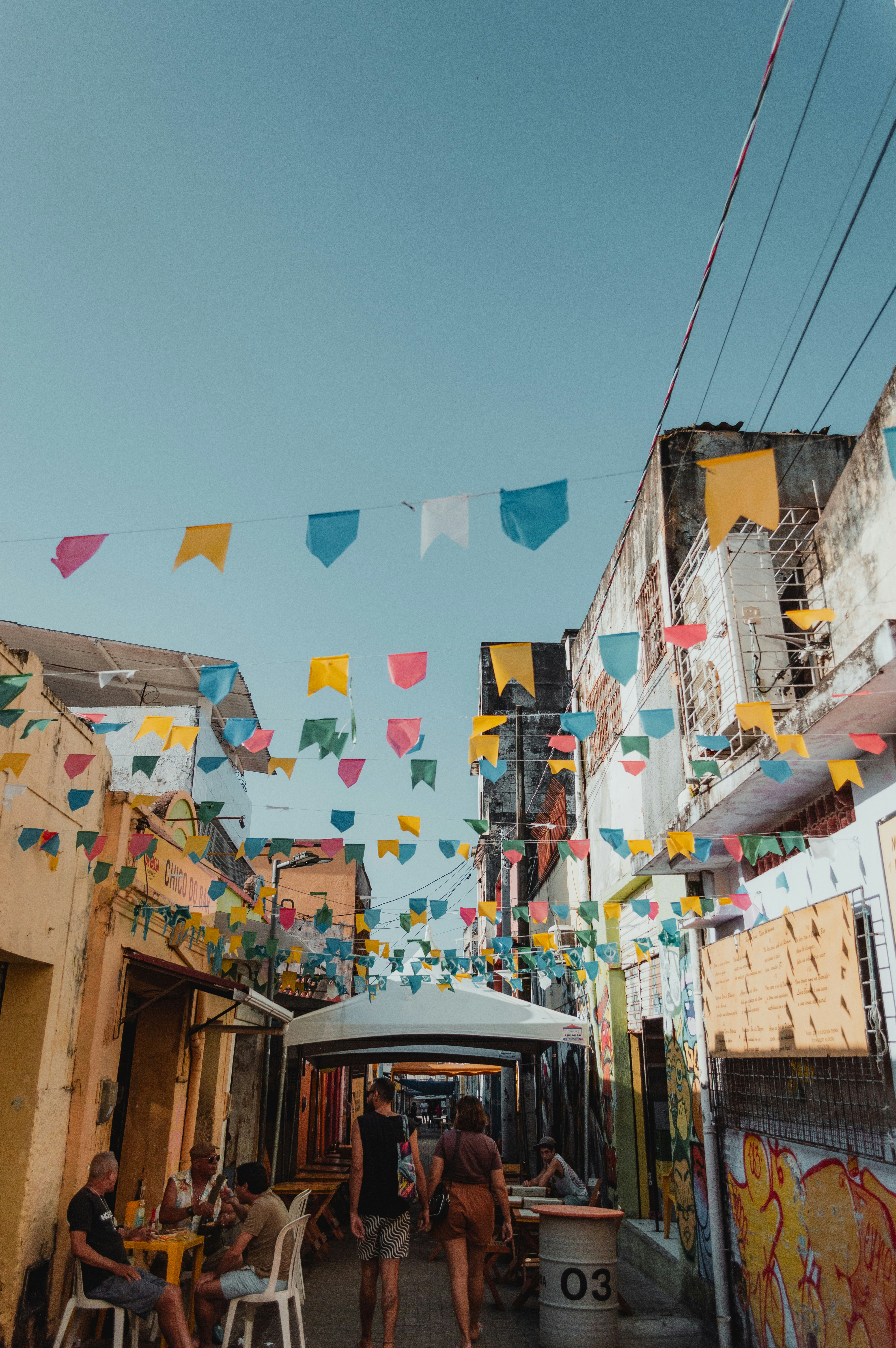 Festive Flags Over a Lively Calle: People, Colors, and City Graffiti
